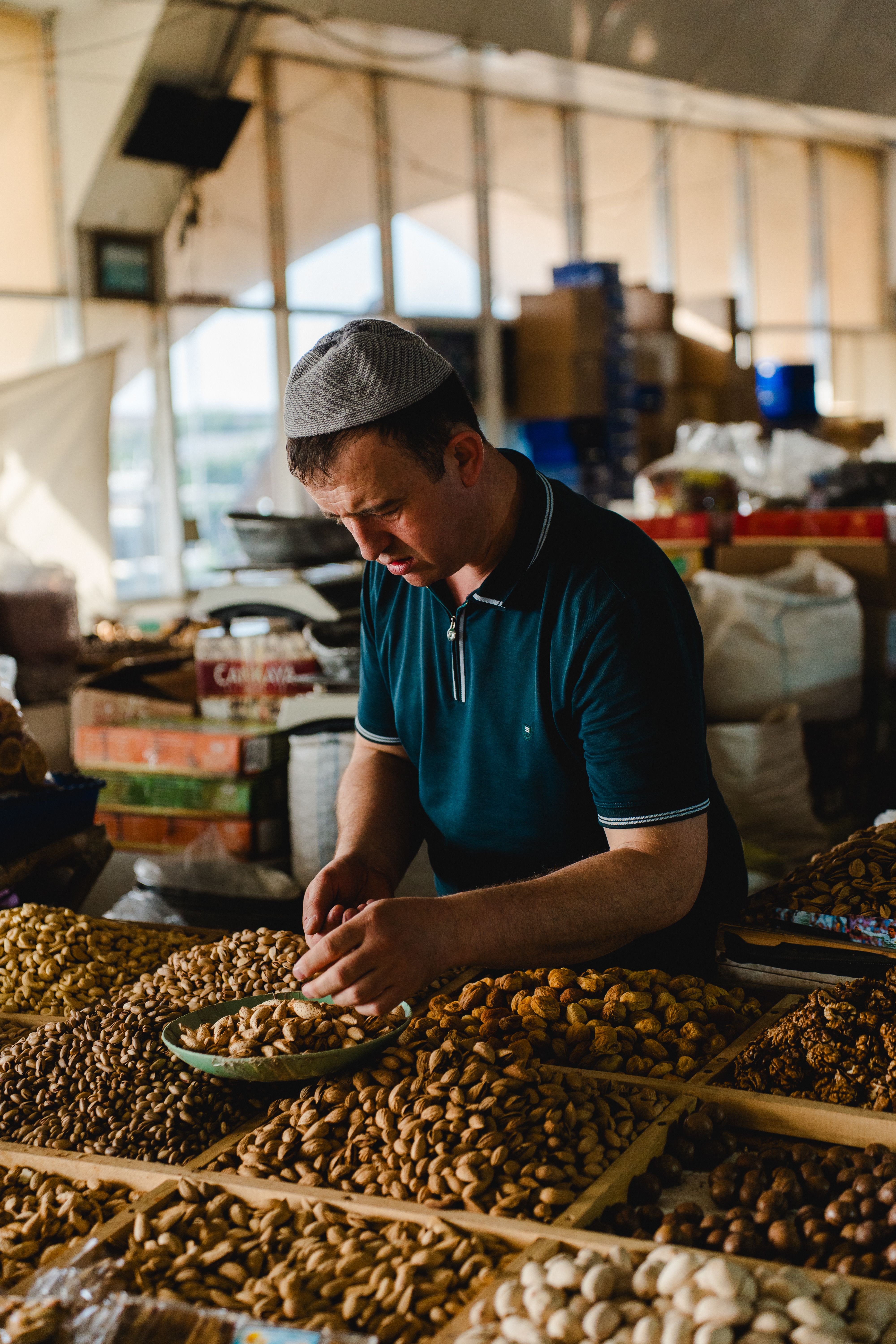 Man Selling Nuts at a Bustling Market Stall · Free Stock Photo
