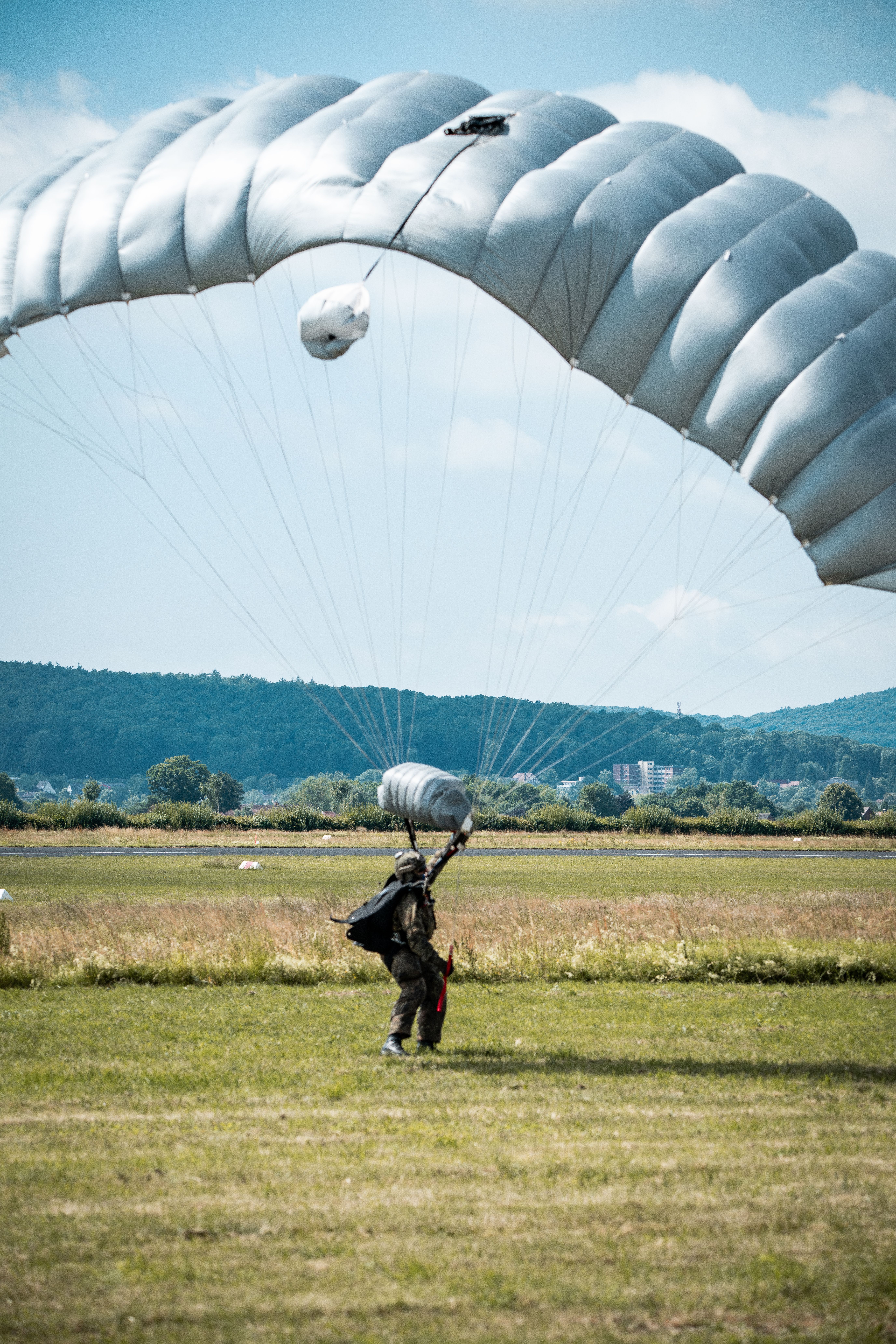Paratrooper Landing in Open Field During Training · Free Stock Photo