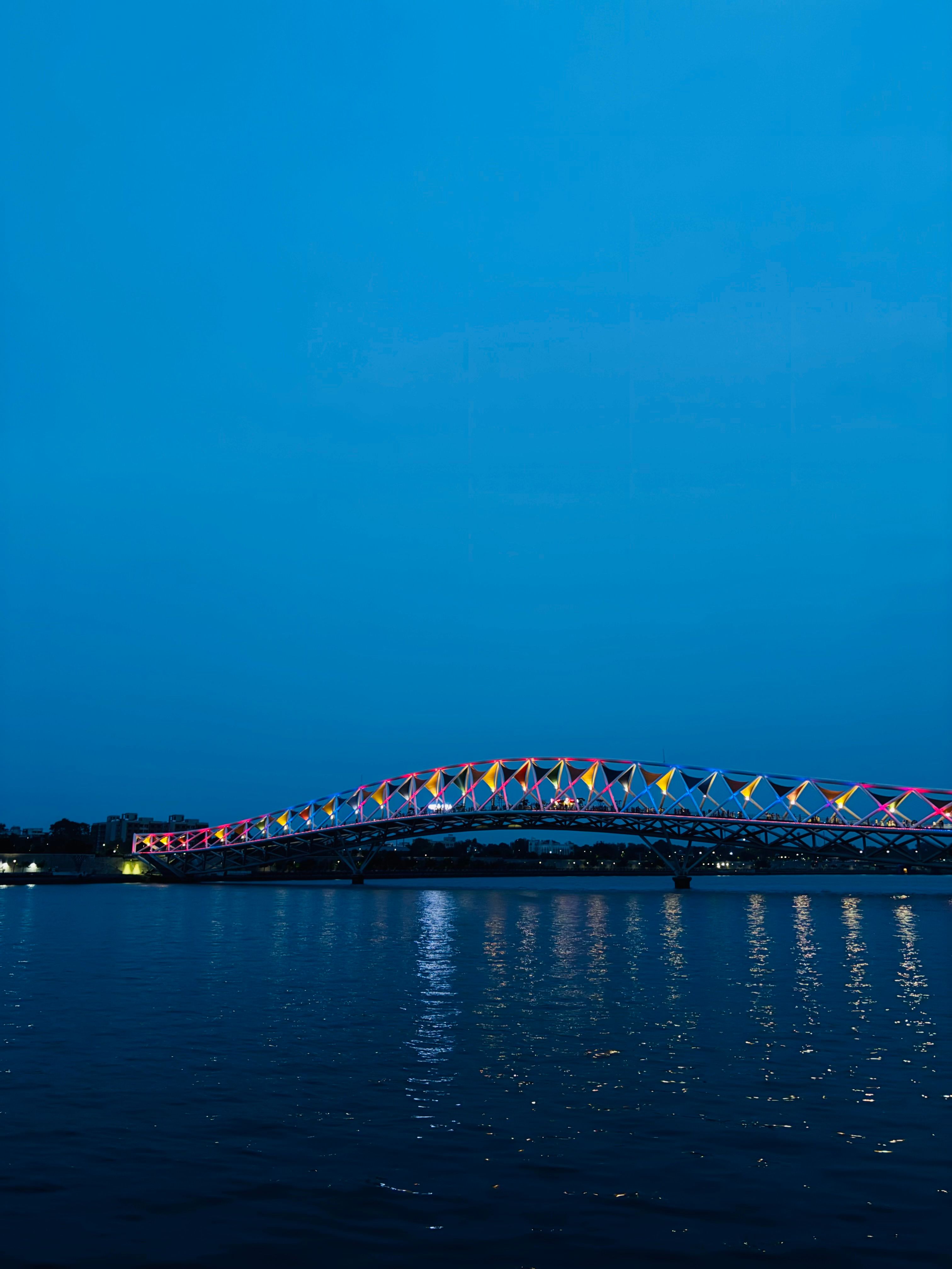 Vibrant Illuminated Bridge Over Water at Night · Free Stock Photo