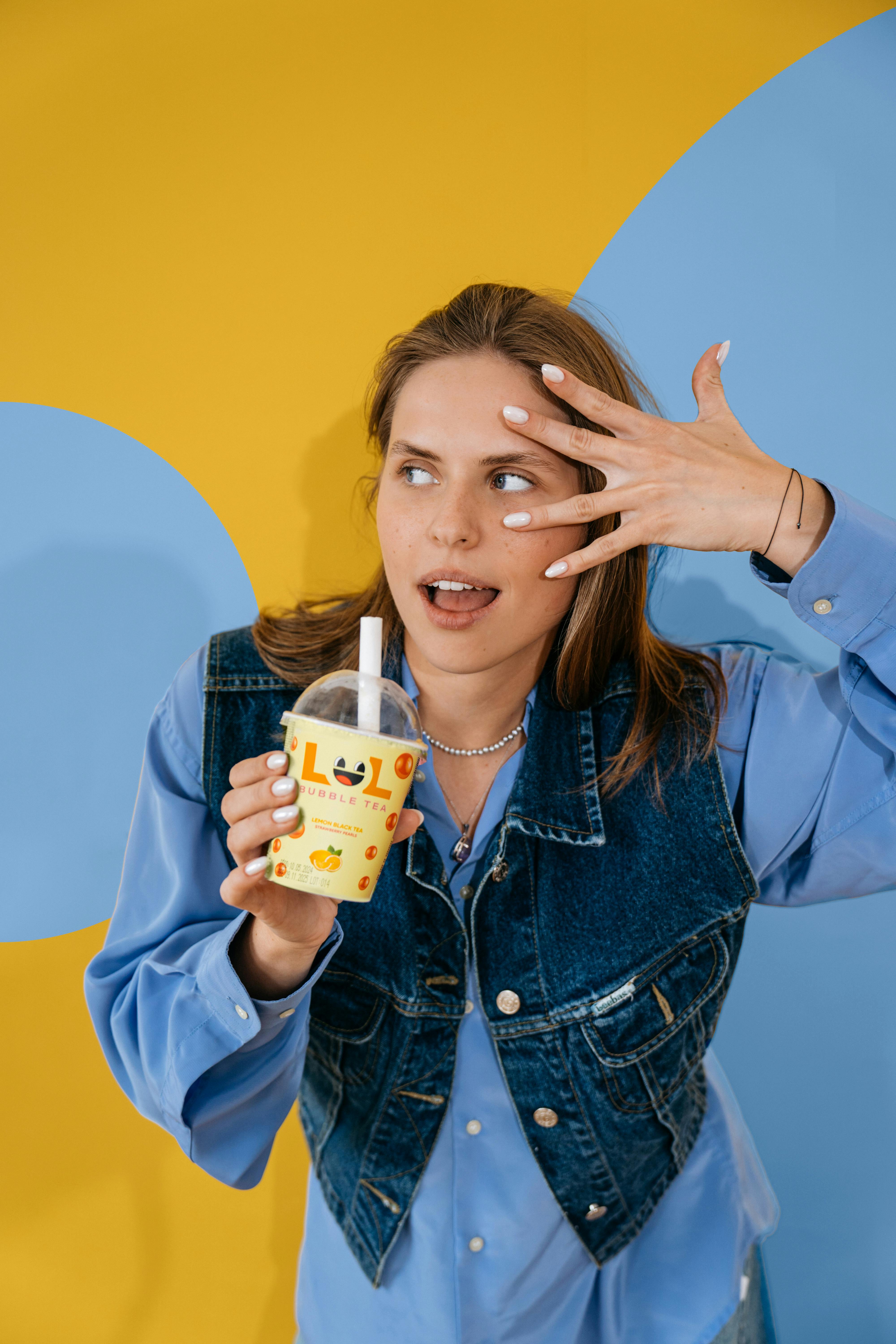 Young Woman Enjoying Bubble Tea with Fun Expression · Free Stock Photo