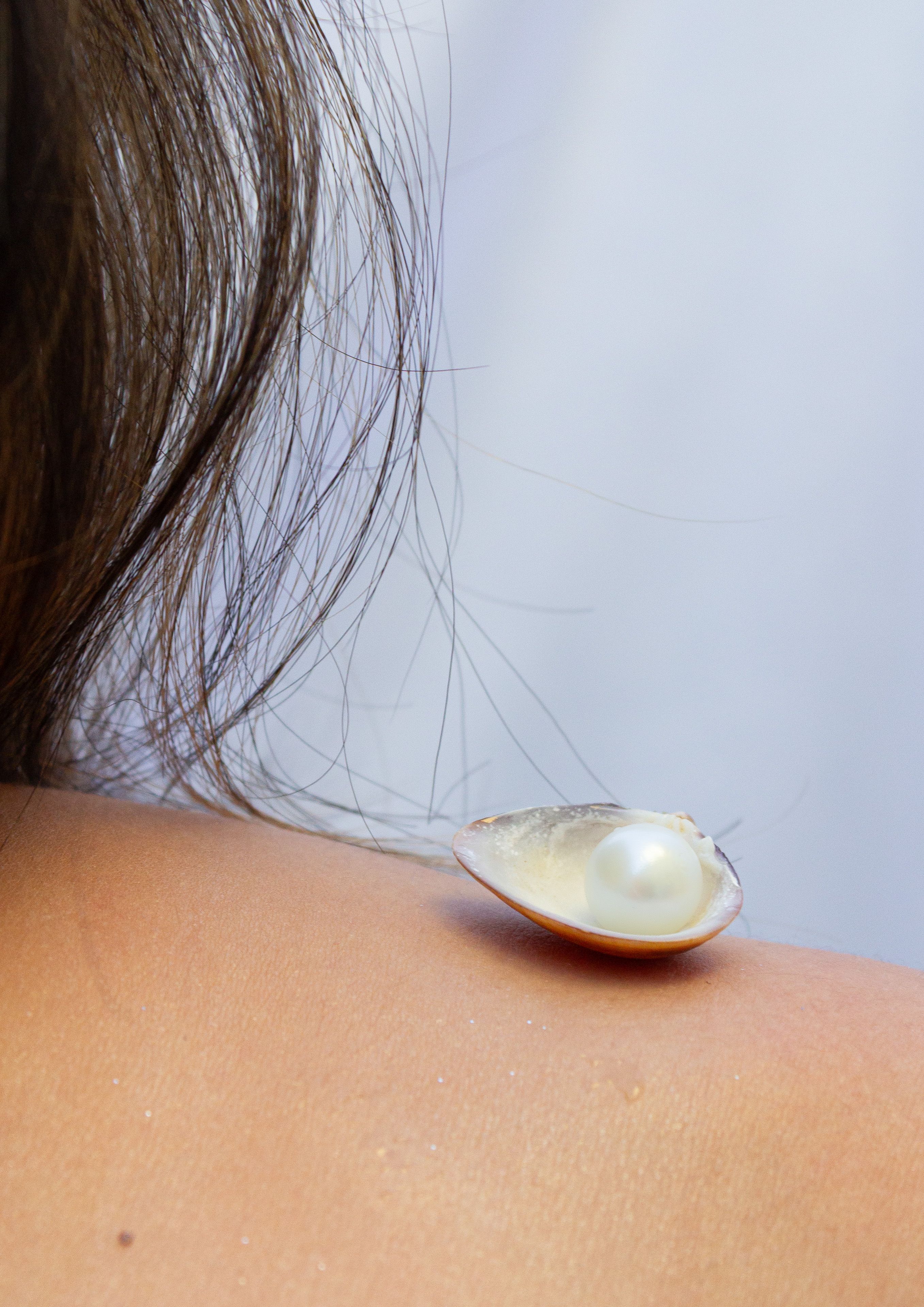 Close-up of Pearl on Shell against Skin · Free Stock Photo