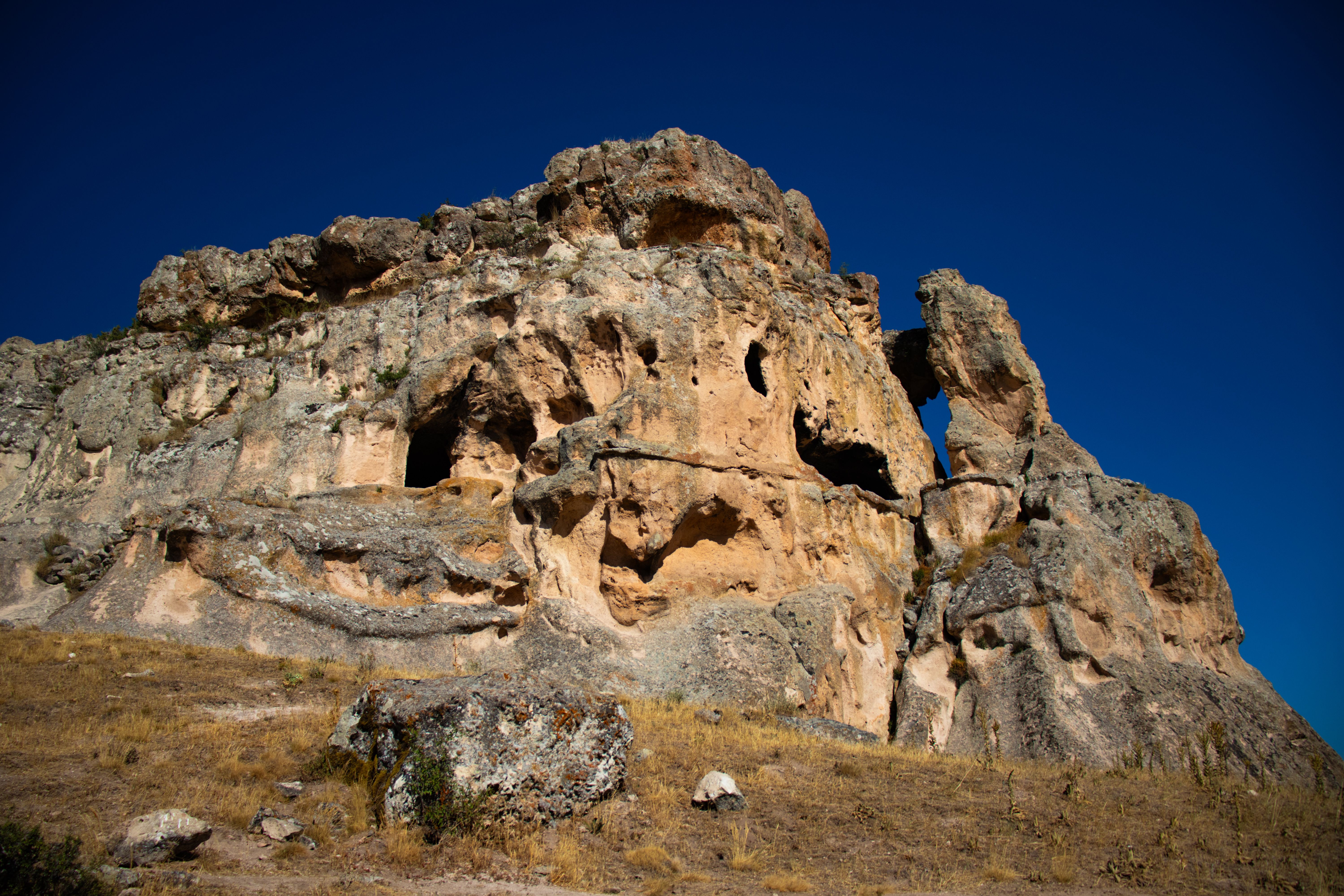 Eroded Rocky Cliff Under Clear Blue Sky · Free Stock Photo