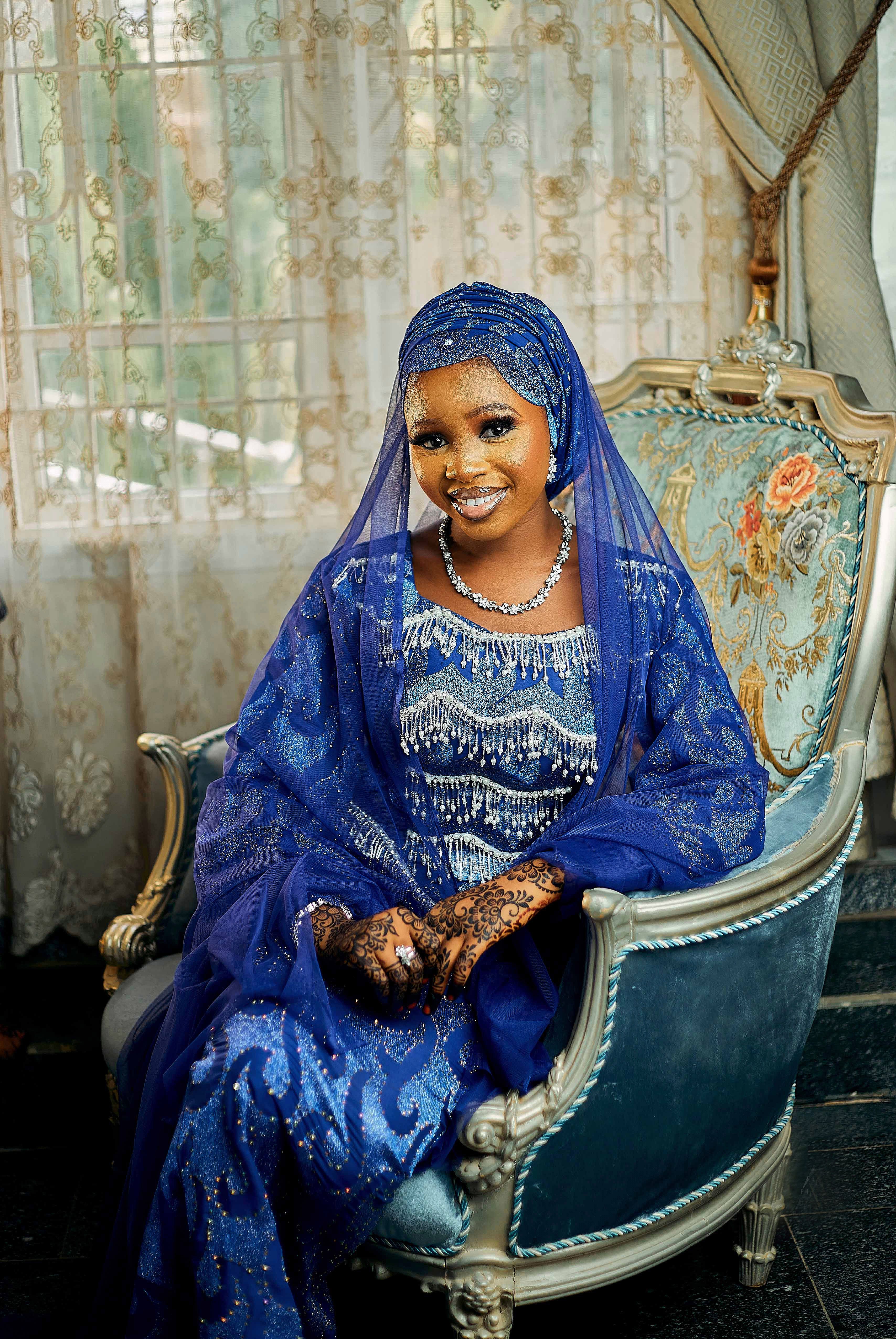 Elegant woman in traditional blue attire seated · Free Stock Photo