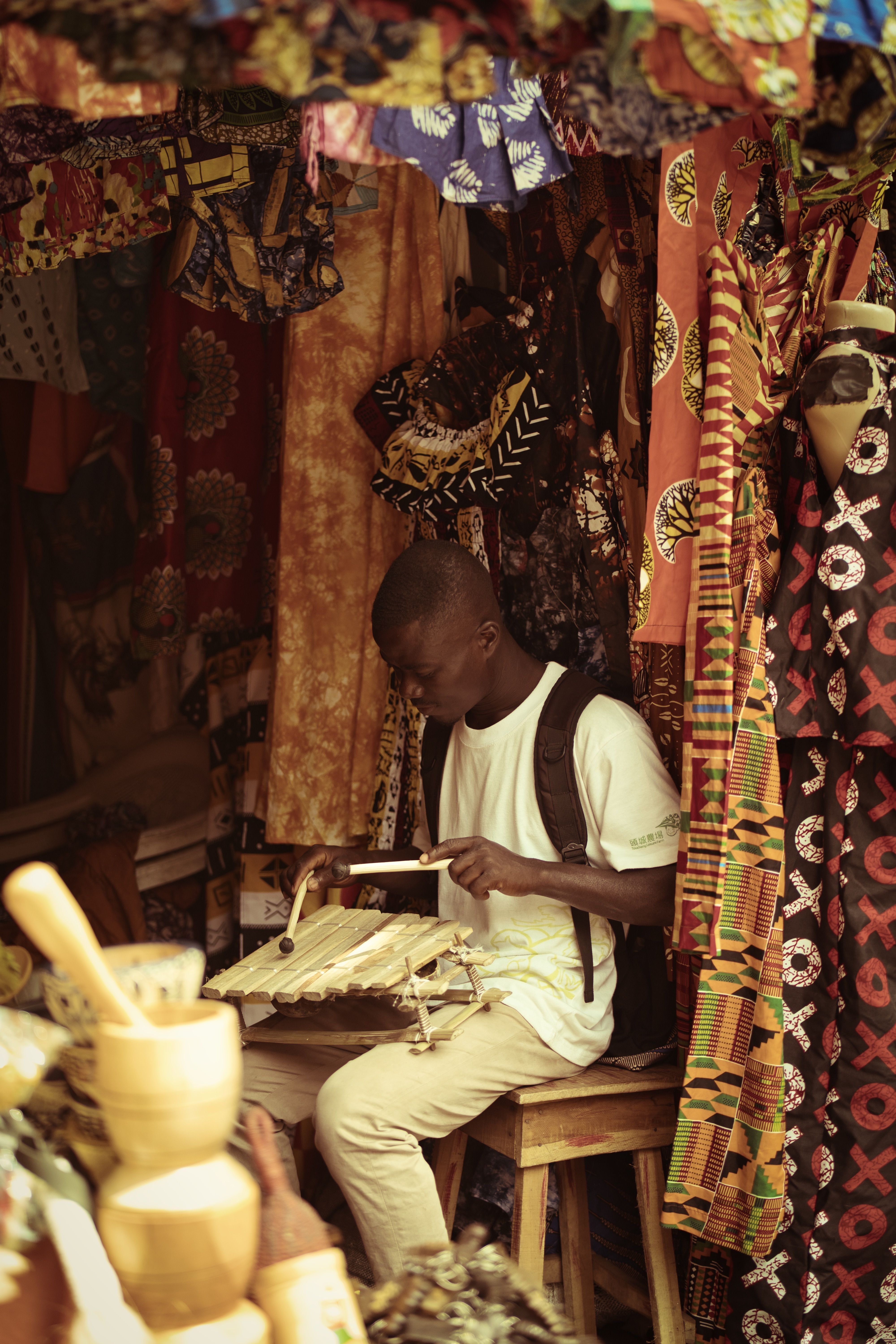 African Vendor in Traditional Garb at Market Stall · Free Stock Photo