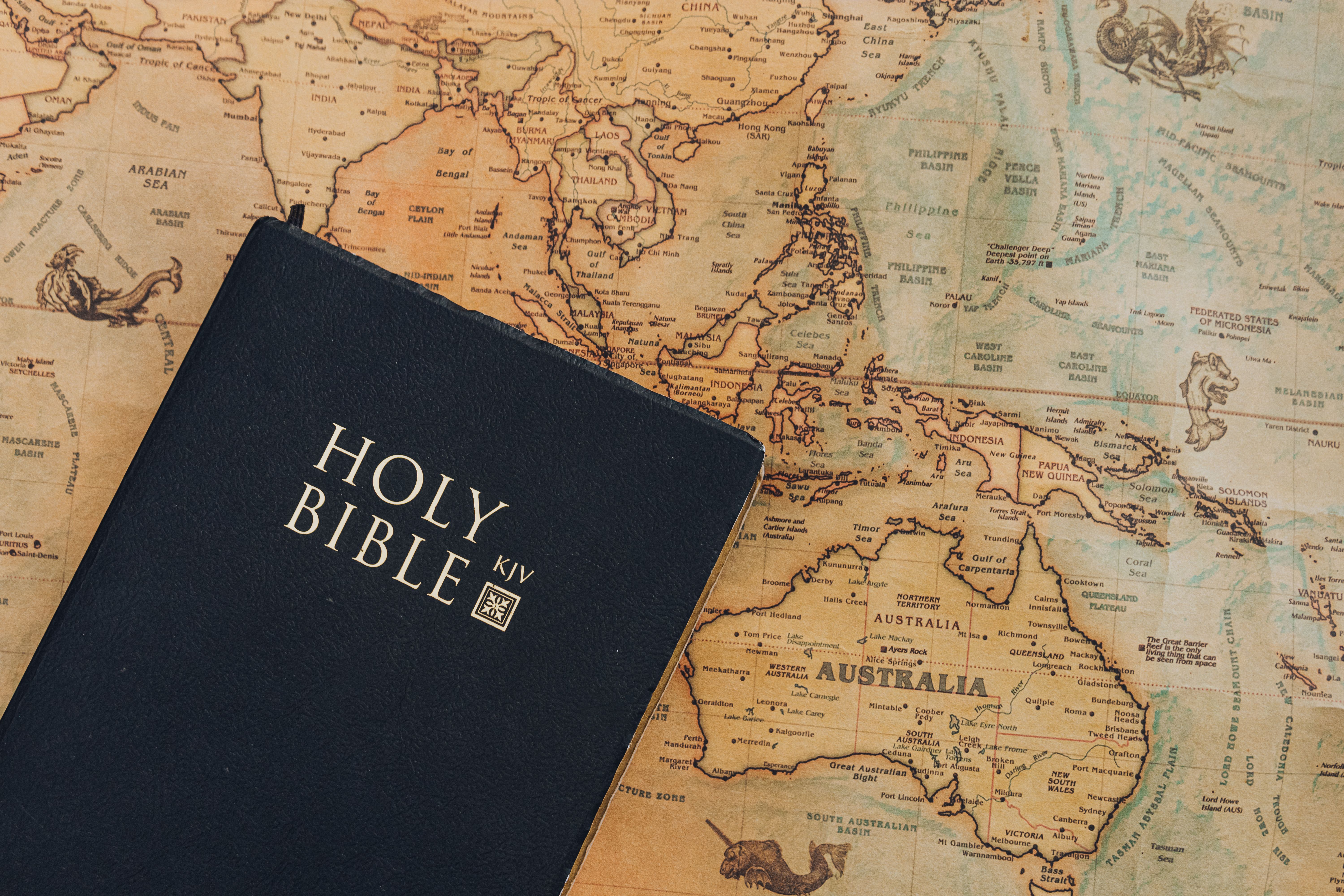 Holy Bible on Vintage World Map Background · Free Stock Photo