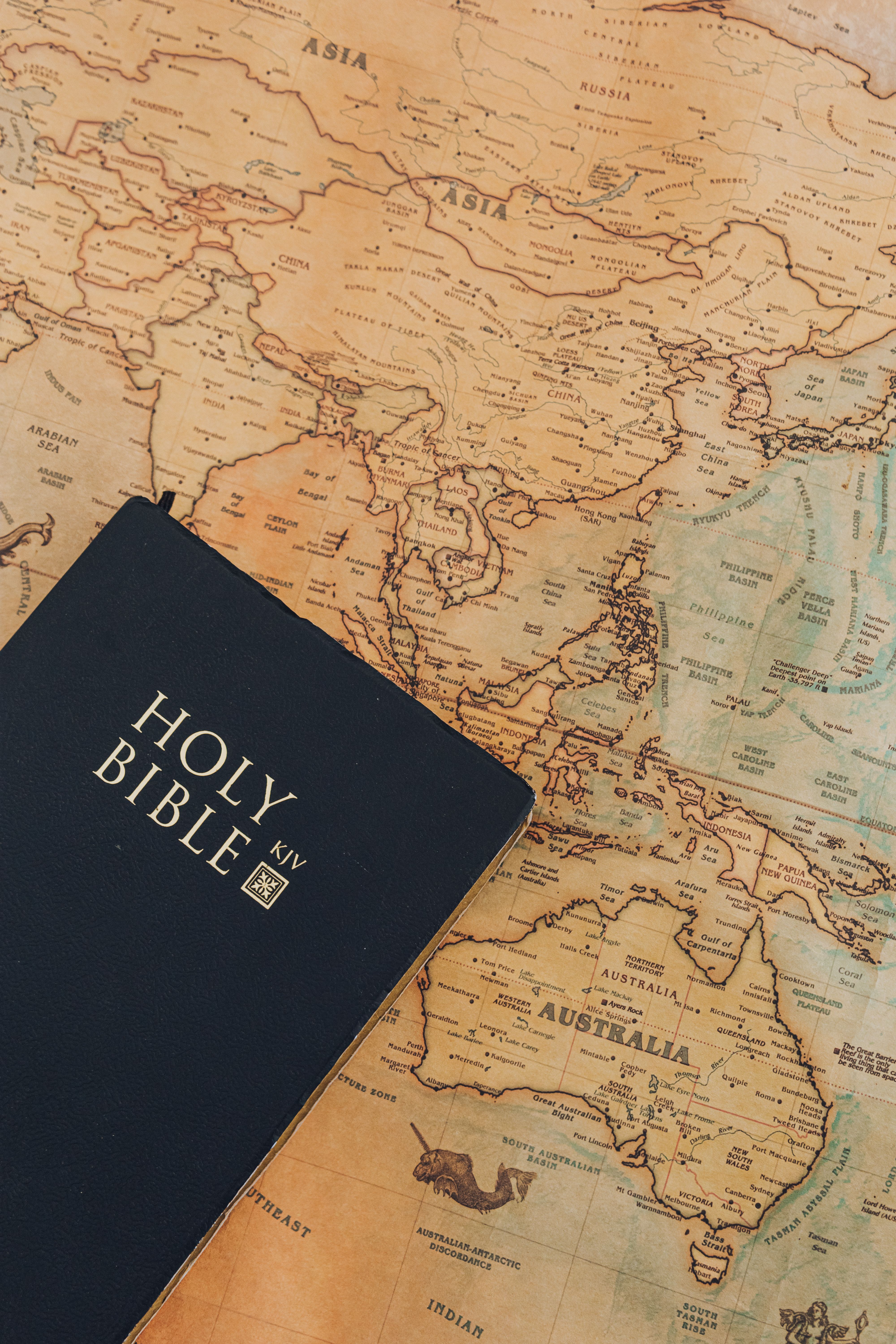 Holy Bible on Vintage World Map with Focus on Asia · Free Stock Photo