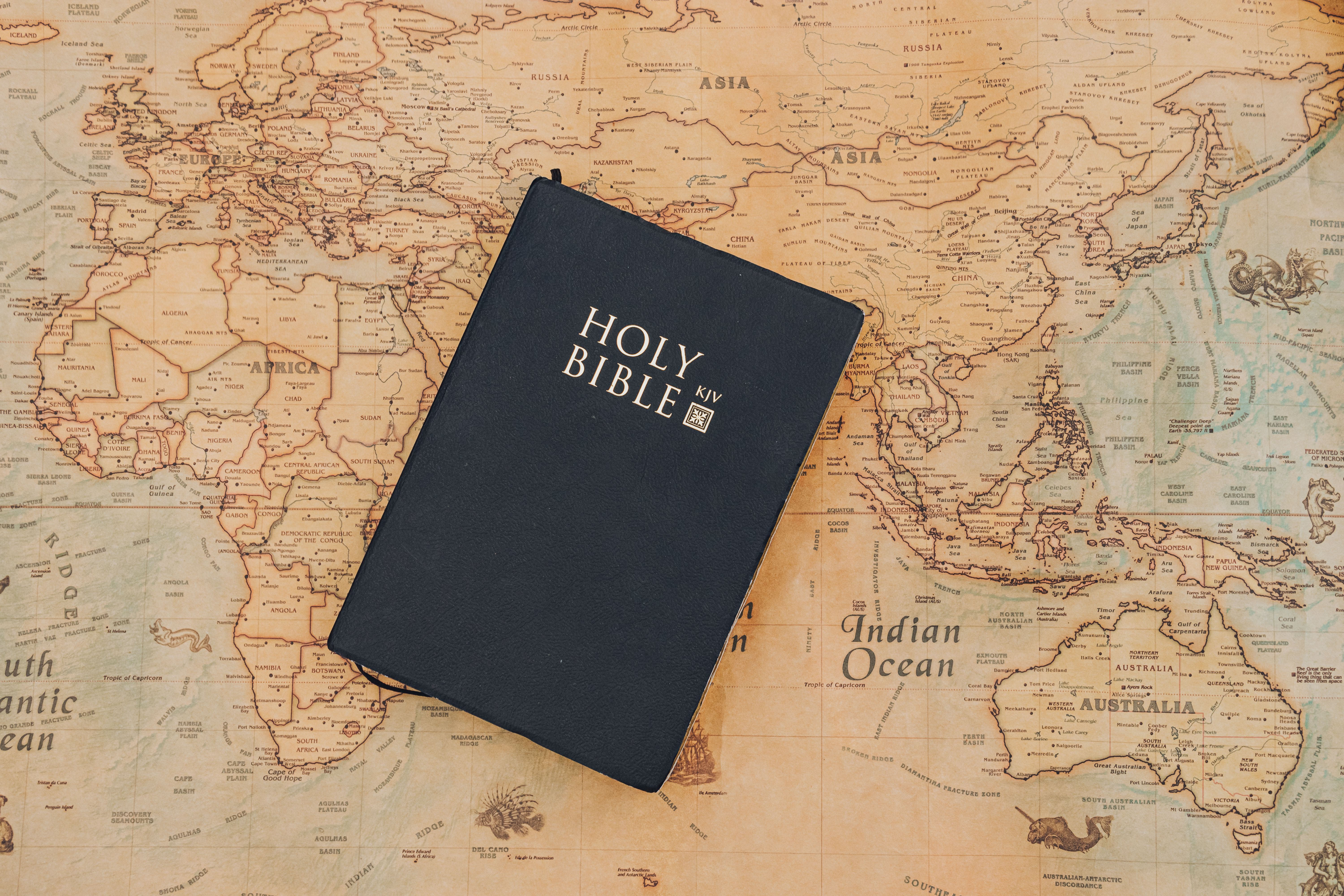 Holy Bible on Vintage World Map Background · Free Stock Photo