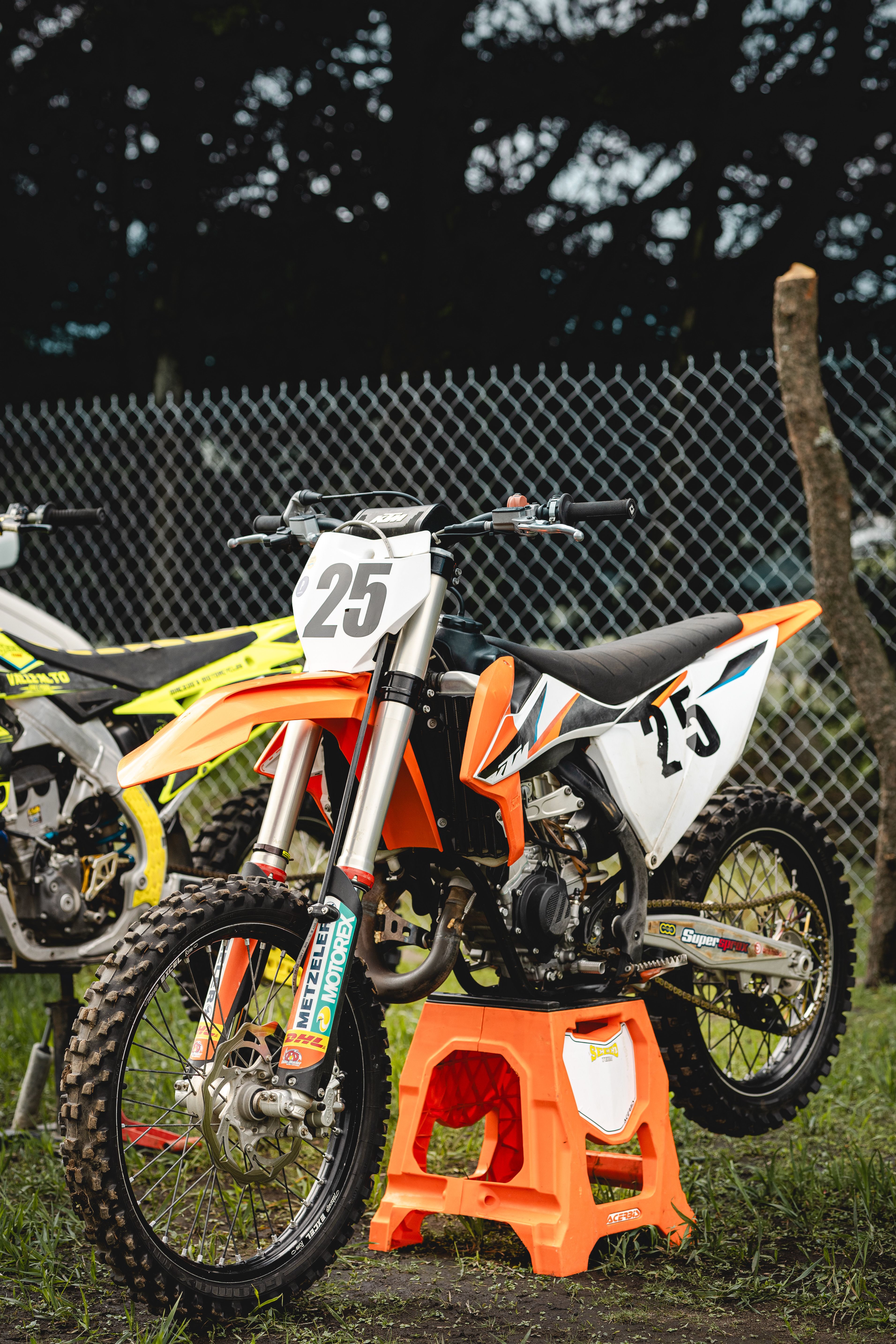Vibrant Orange Motocross Bike on Stand Outdoors · Free Stock Photo