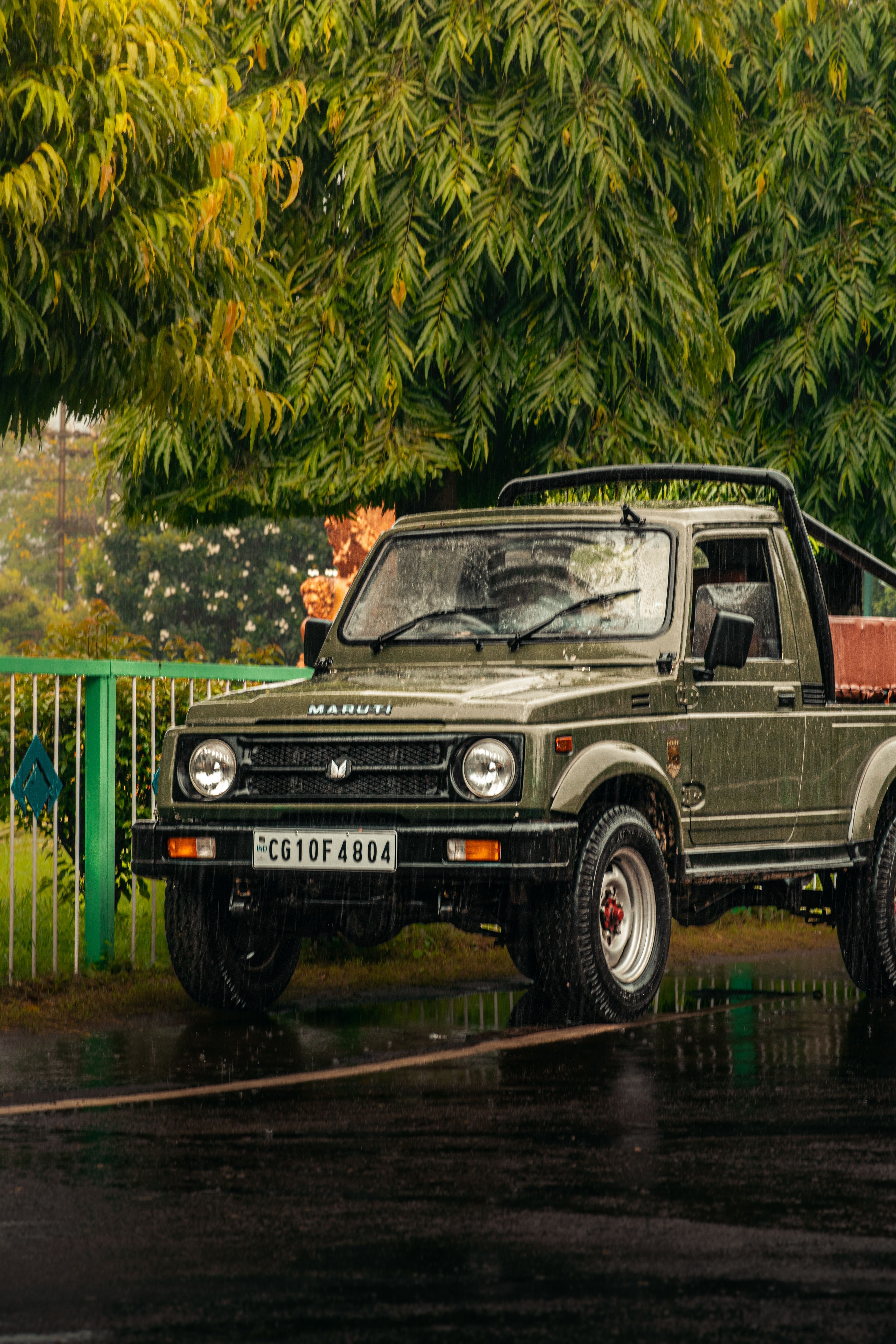 Vintage Green Off-Road Vehicle on Wet Road · Free Stock Photo