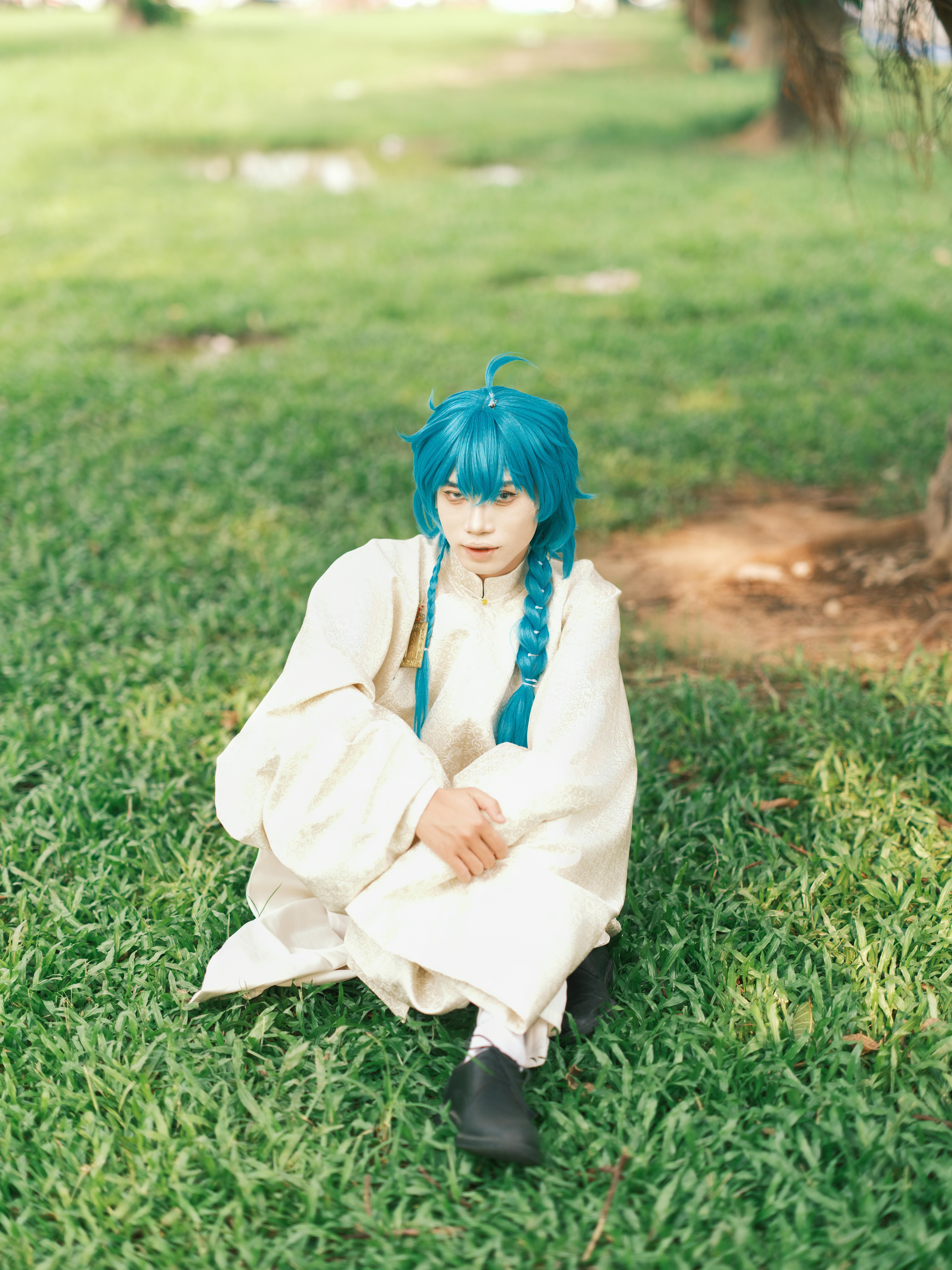 Cosplayer with Blue Wig Sitting Outdoors · Free Stock Photo