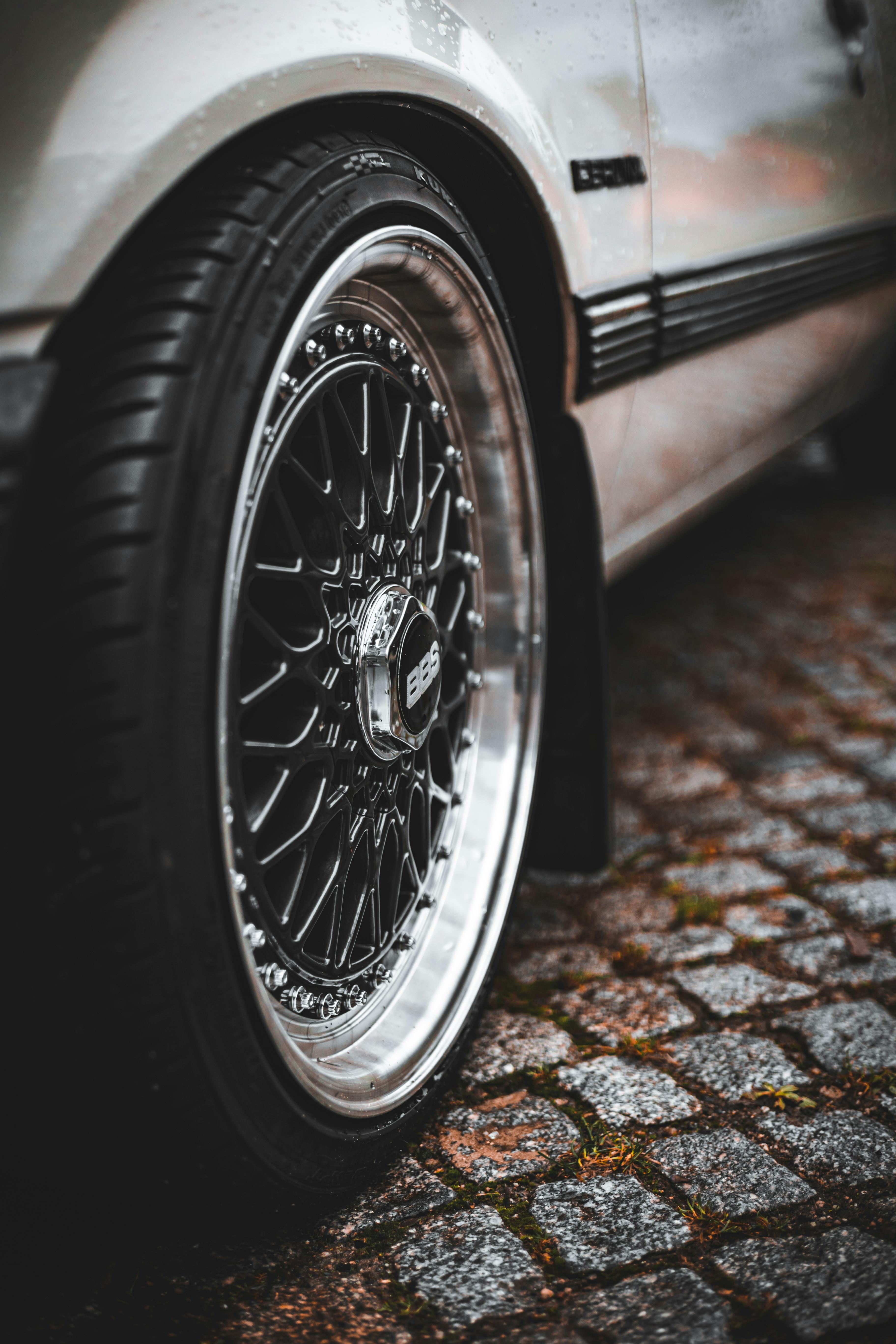 Close-up of Luxury Car Wheel on Cobblestone Street · Free Stock Photo