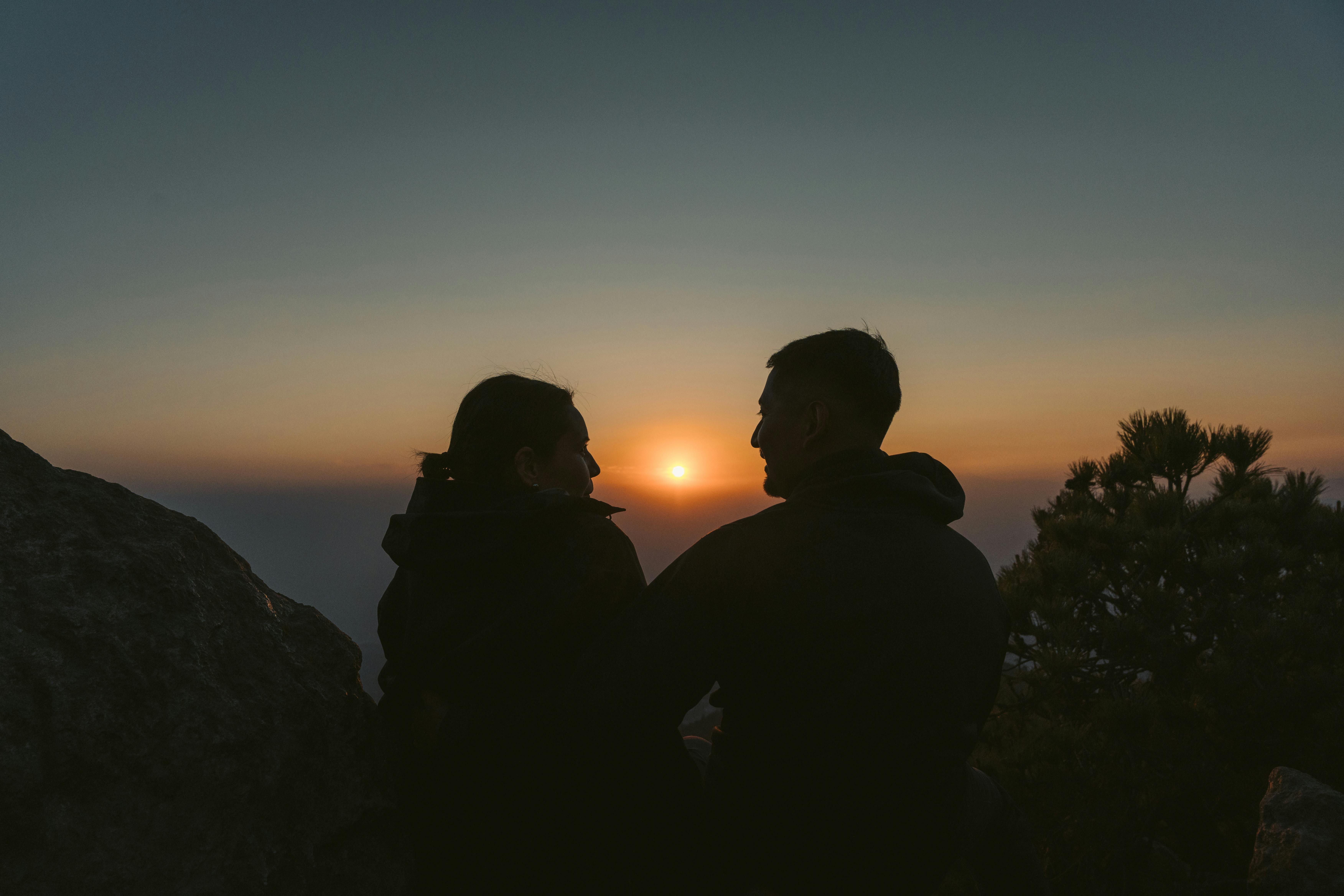 Silhouette of Couple Embracing Sunset on Mountain Peak · Free Stock Photo