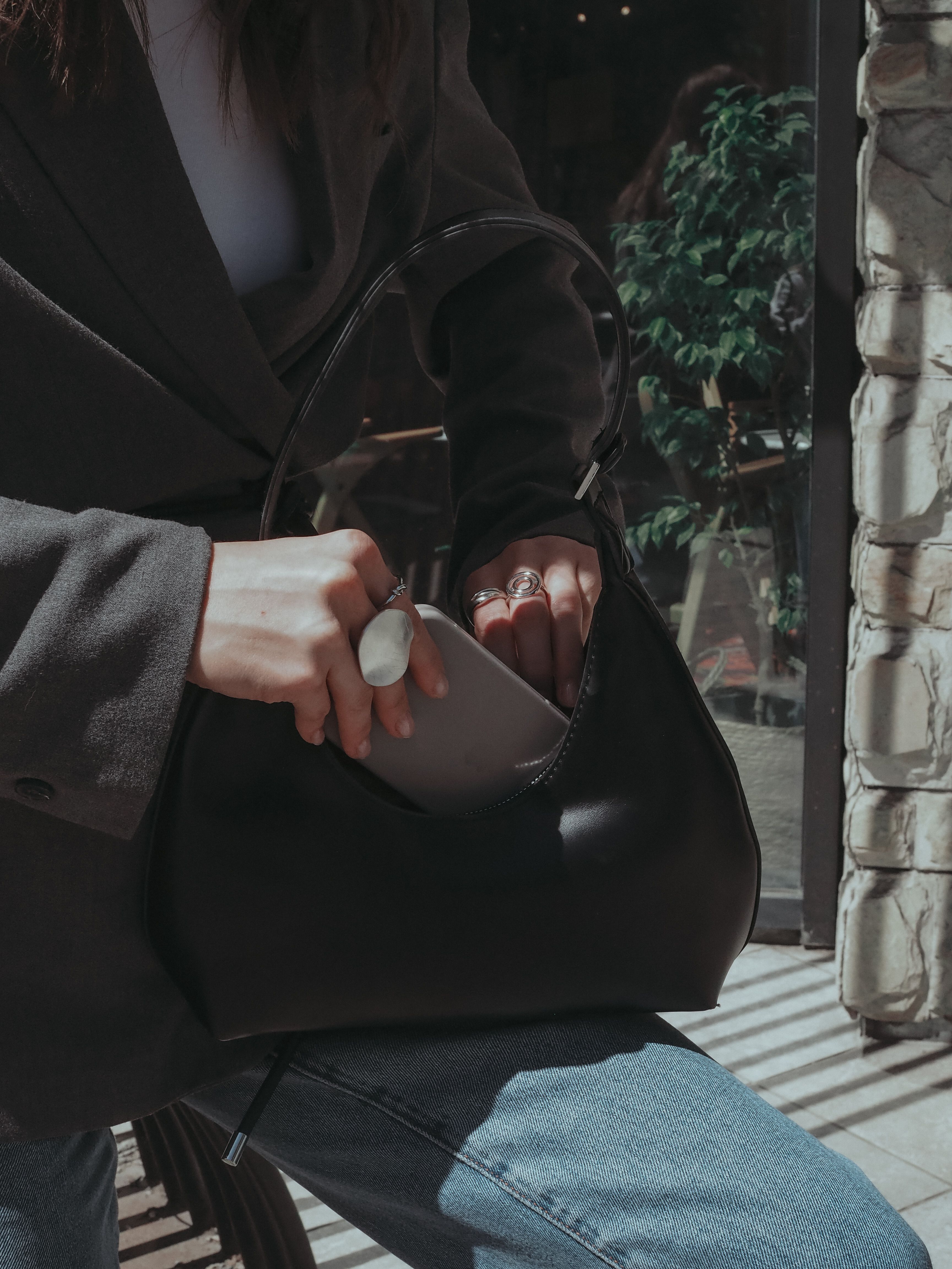 Woman Retrieving Item from Black Leather Bag · Free Stock Photo