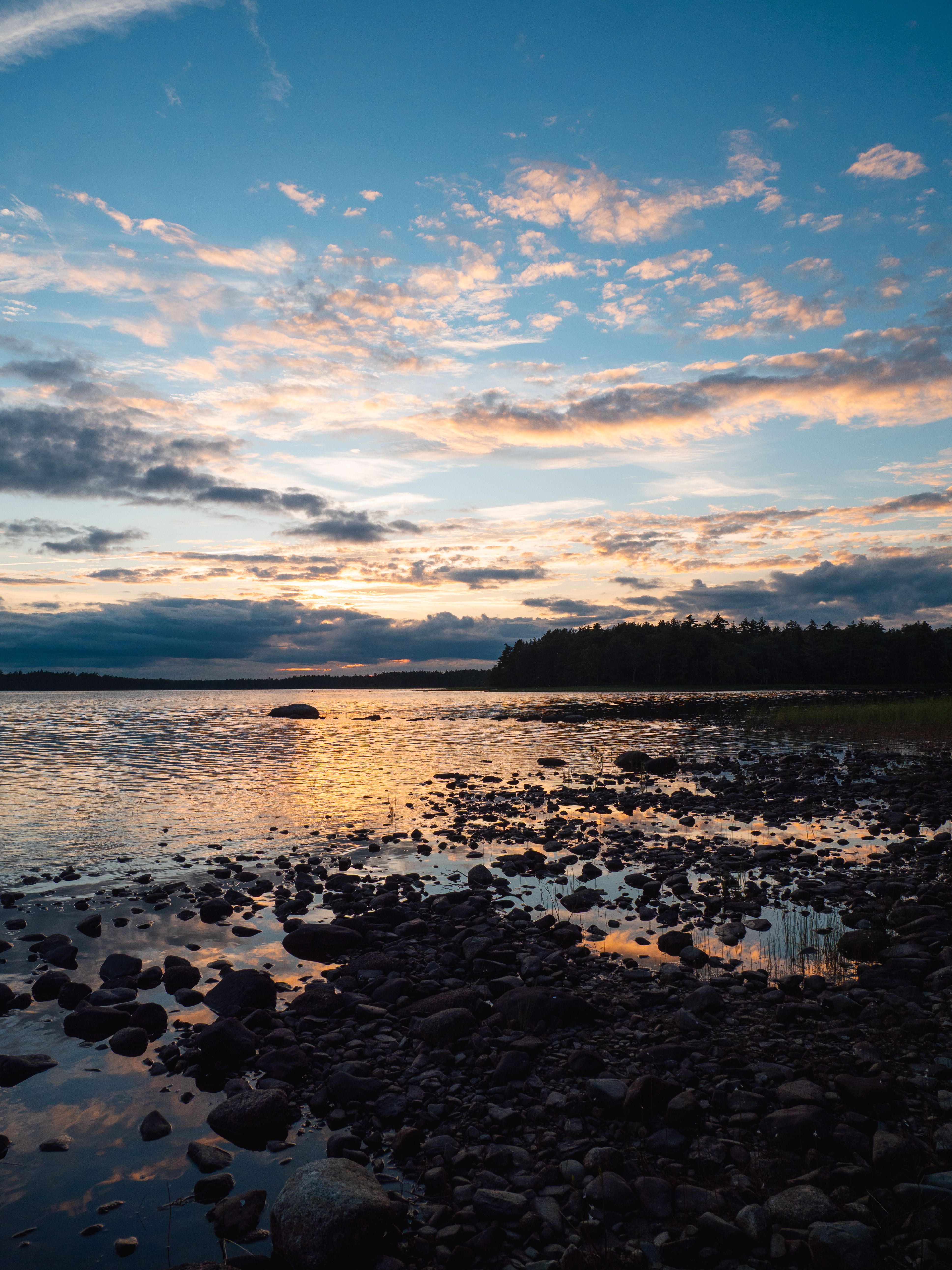 Serene Sunset Over Rocky Lakeshore · Free Stock Photo