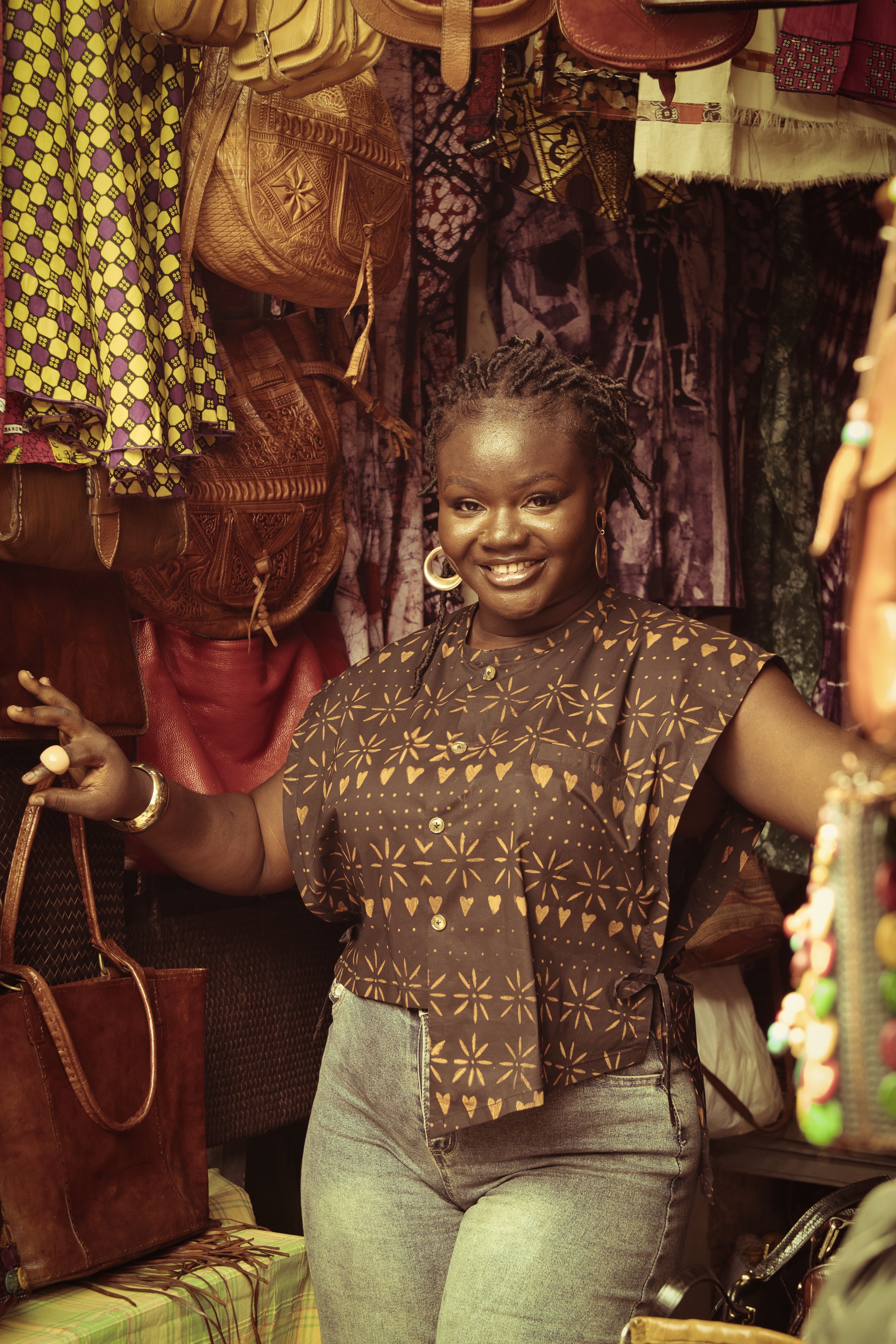 Smiling Woman in Vibrant African Market Stall · Free Stock Photo