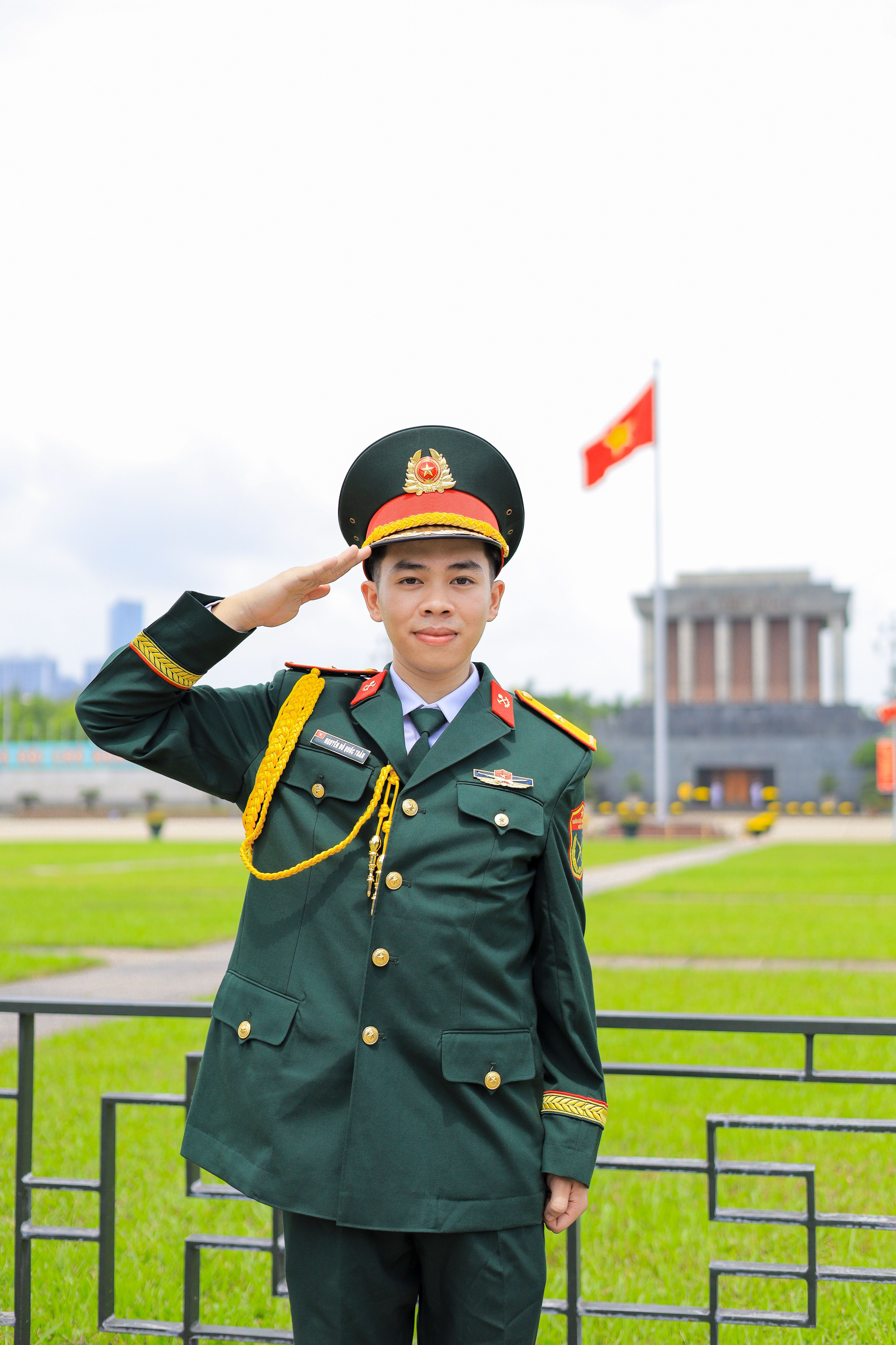 Vietnamese Soldier Saluting in Front of Landmark · Free Stock Photo