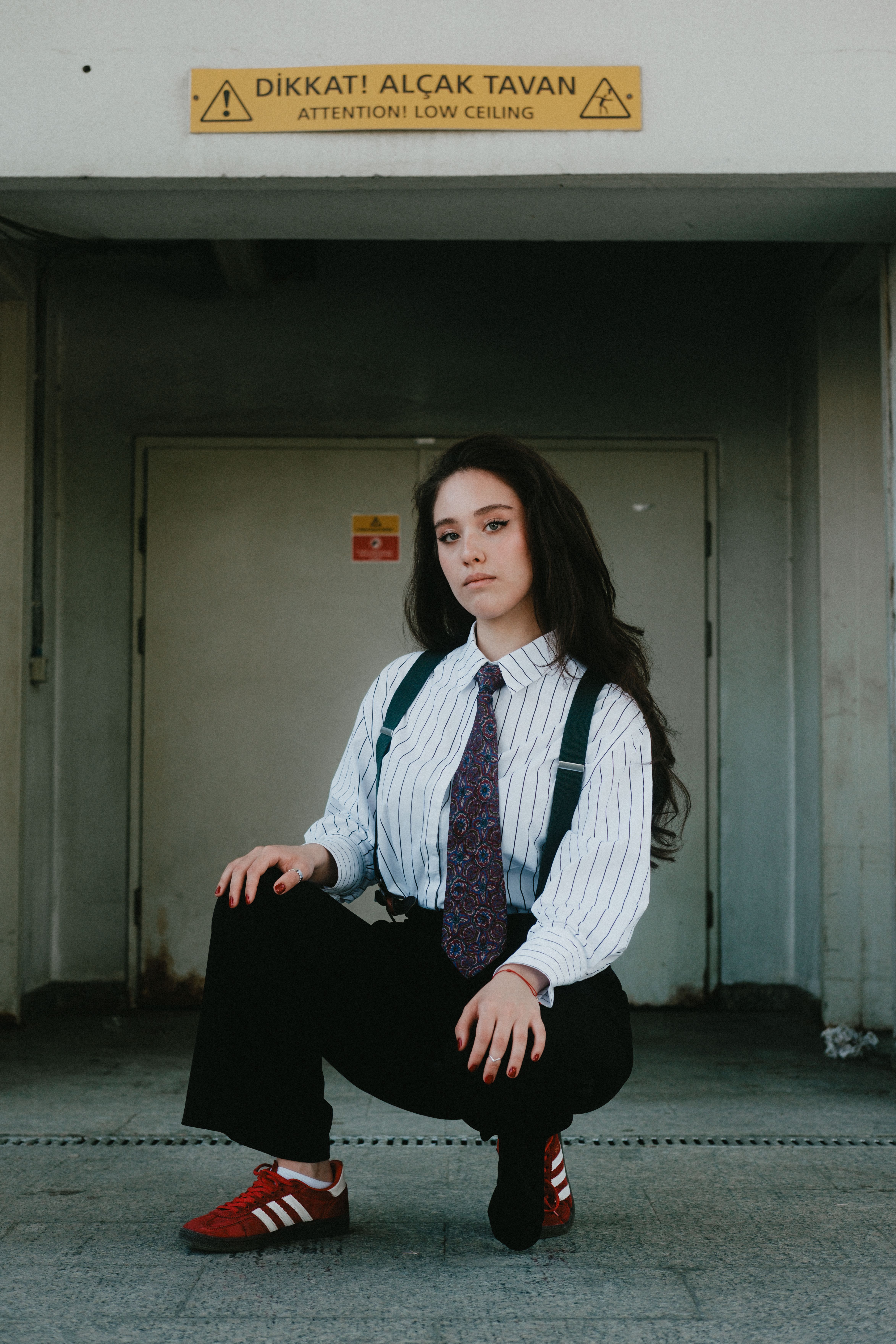 Confident Young Woman Posing Under Low Ceiling Sign · Free Stock Photo