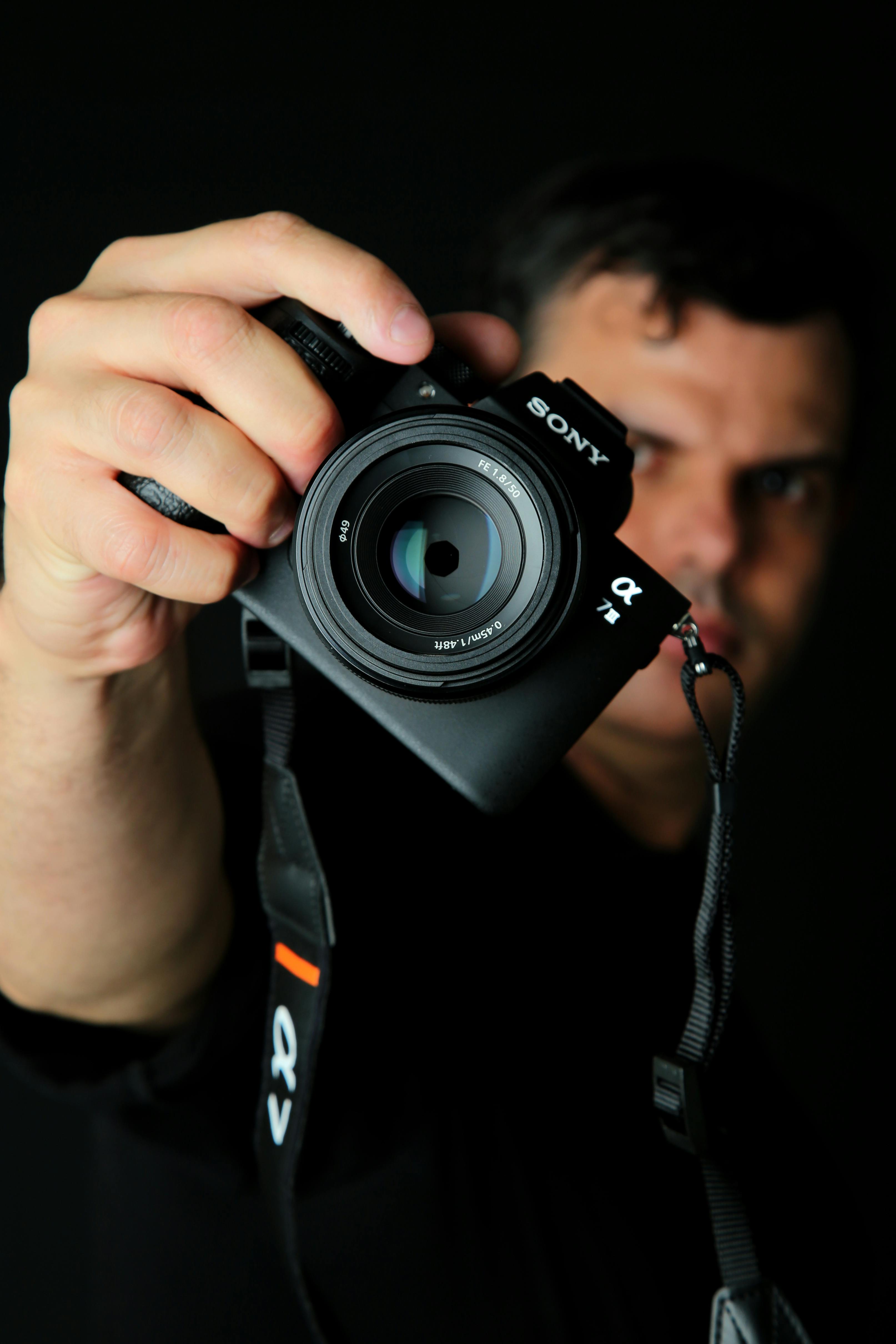Close-up Portrait of a Photographer Holding a Camera · Free Stock Photo