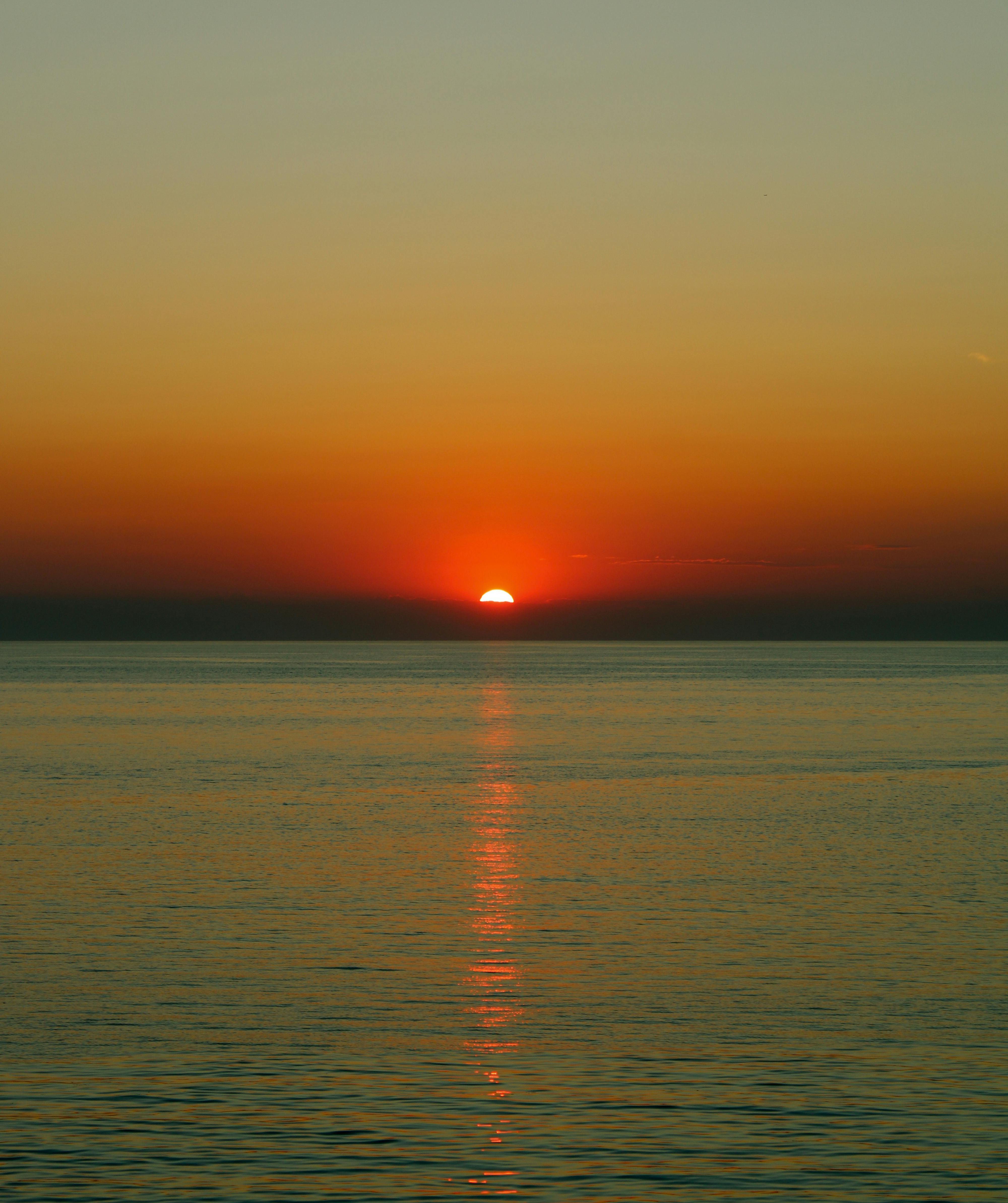 Serene Ocean Sunset with Silhouette Boat · Free Stock Photo