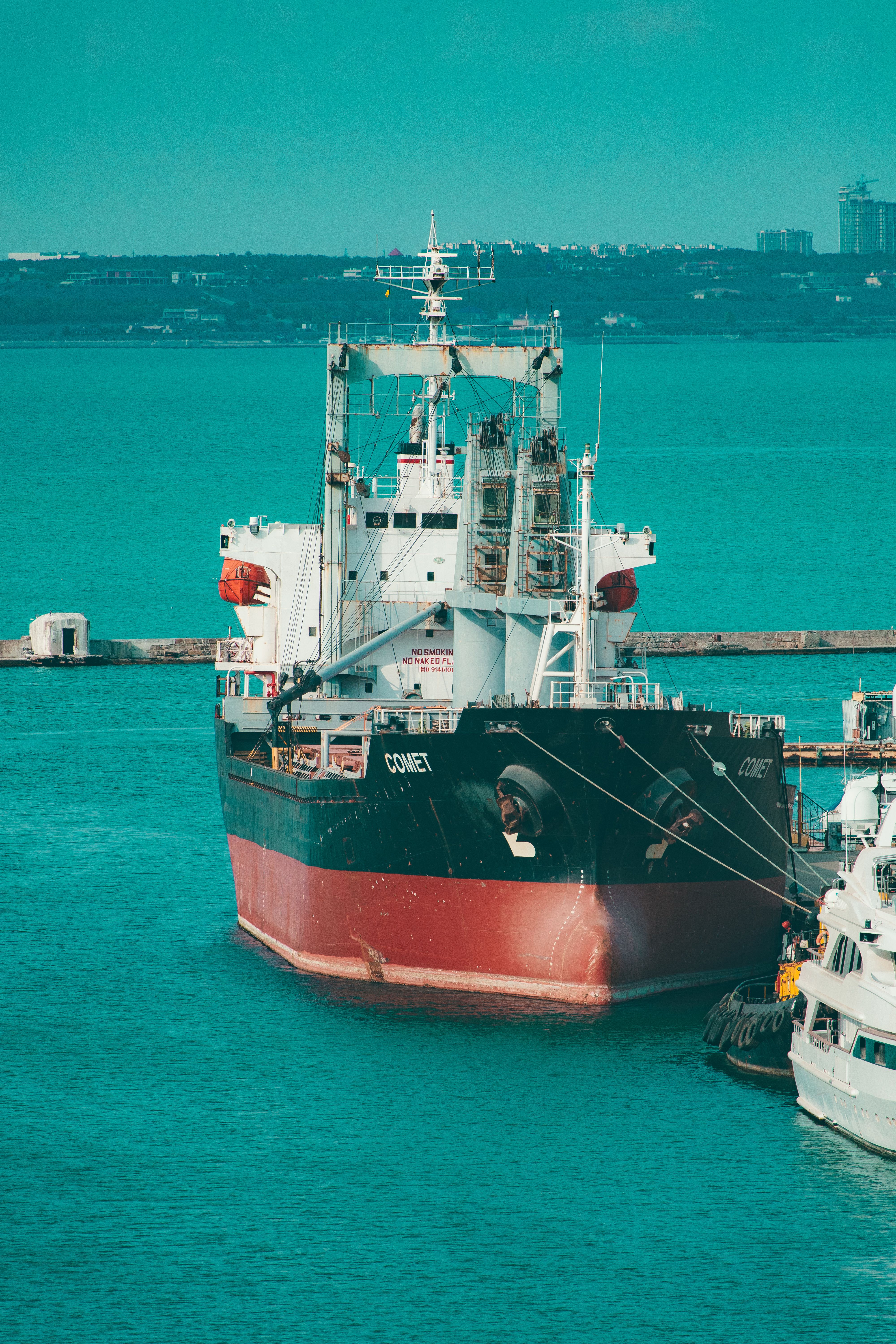 Large Cargo Ship Docked at a Bustling Harbor · Free Stock Photo