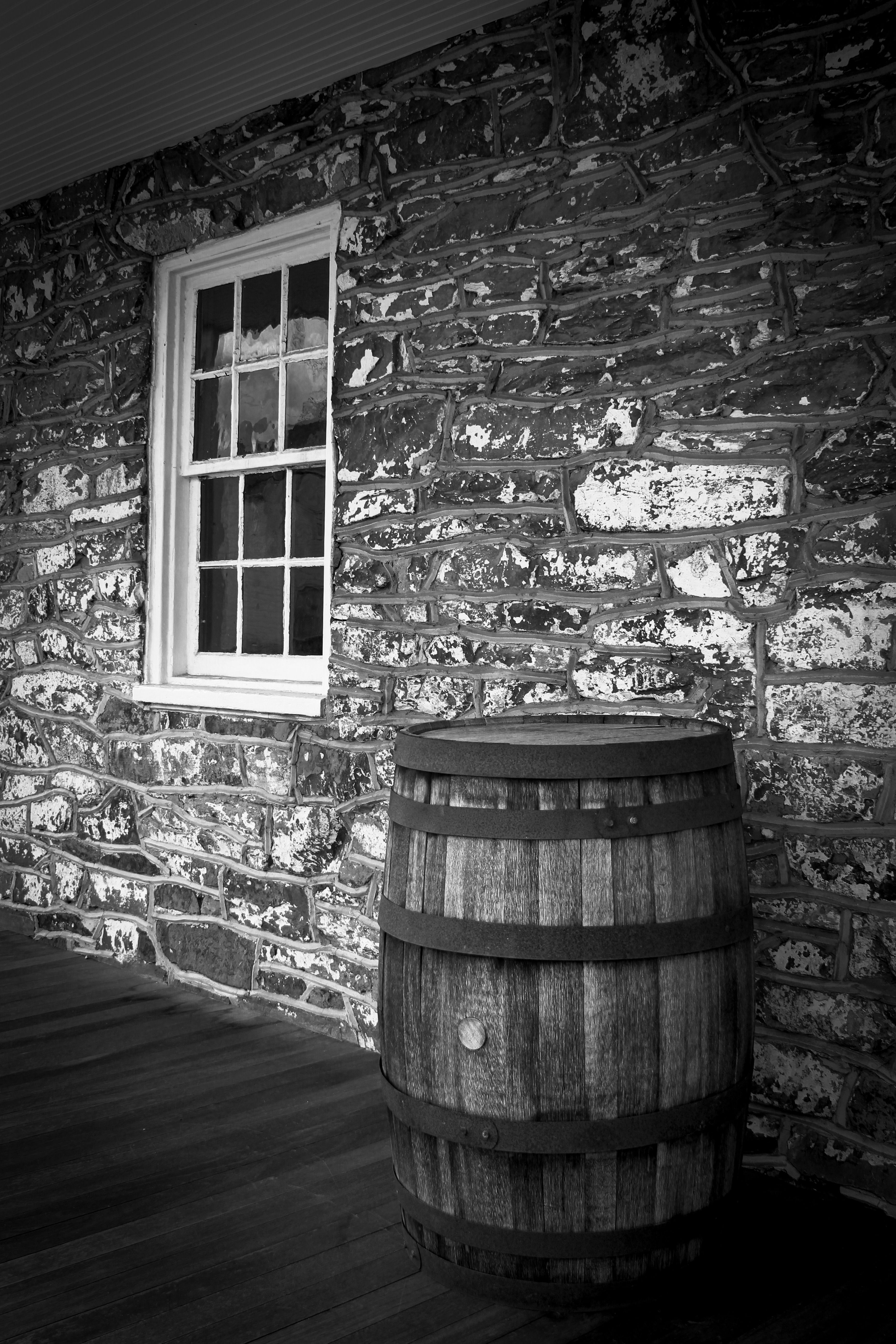 Rustic Barrel Against Stone Wall in Black and White · Free Stock Photo