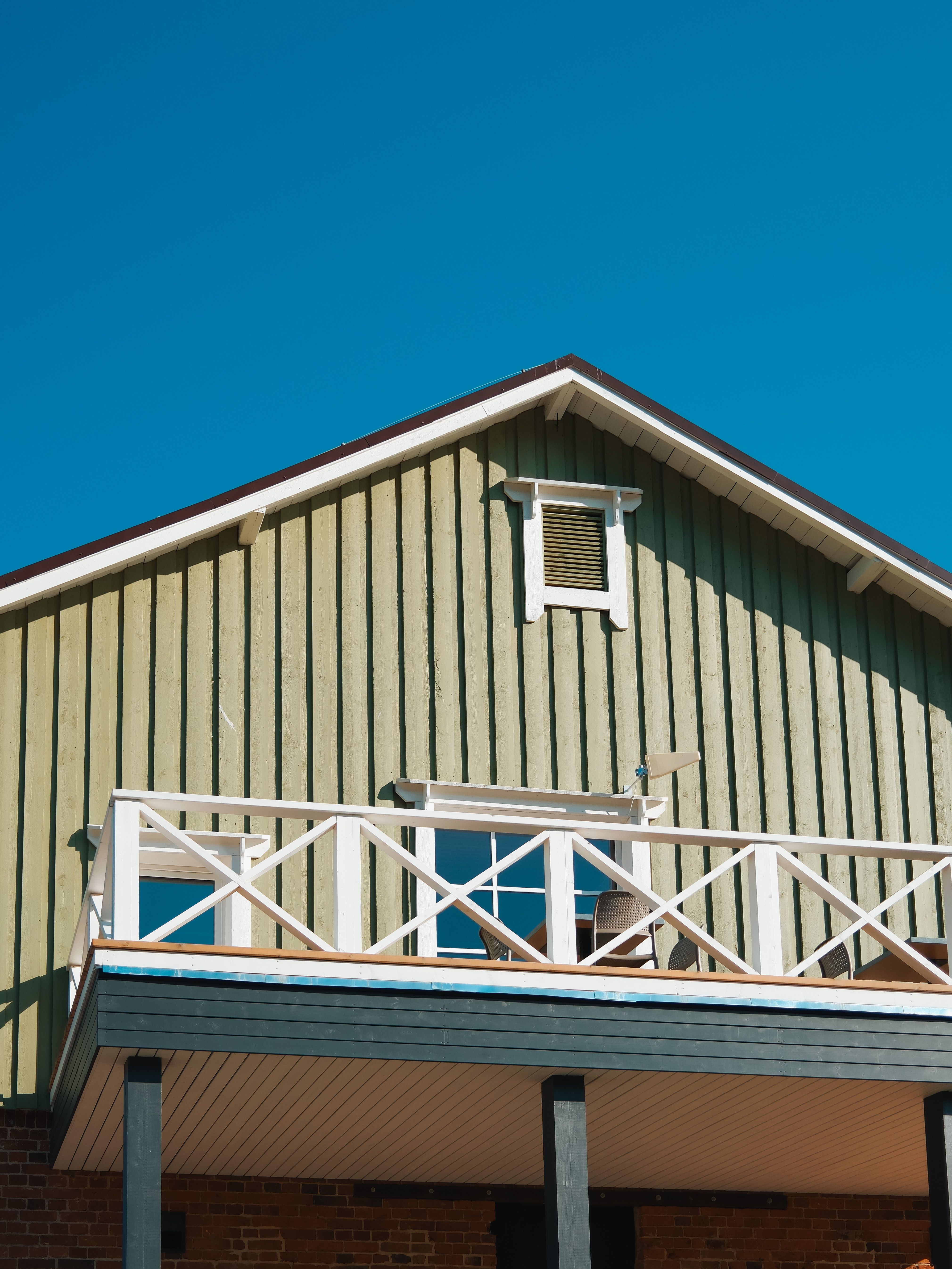 Wooden House Gable Under Clear Blue Sky · Free Stock Photo