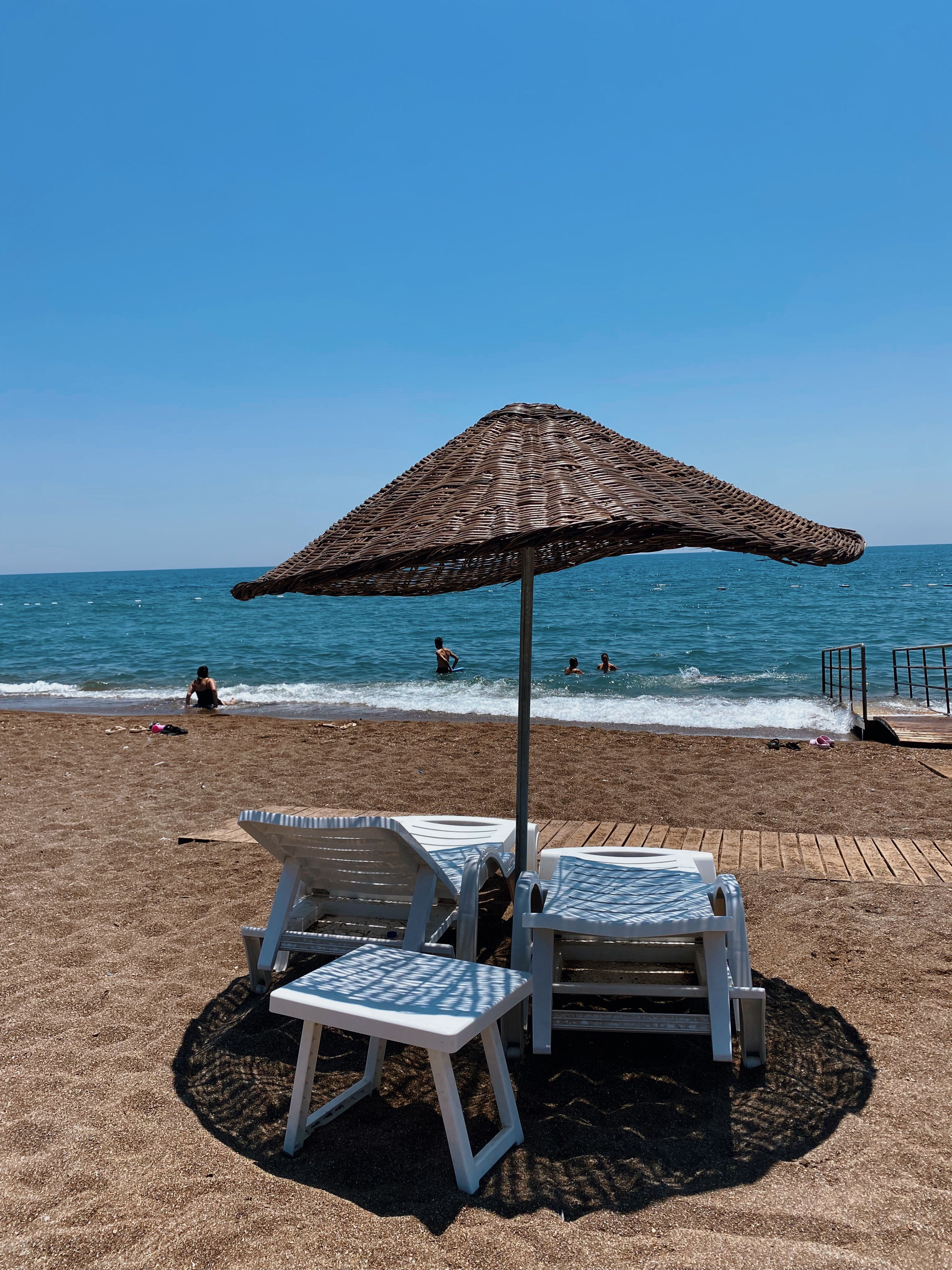 Cozy Beach Scene with Lounge Chairs and Umbrella · Free Stock Photo