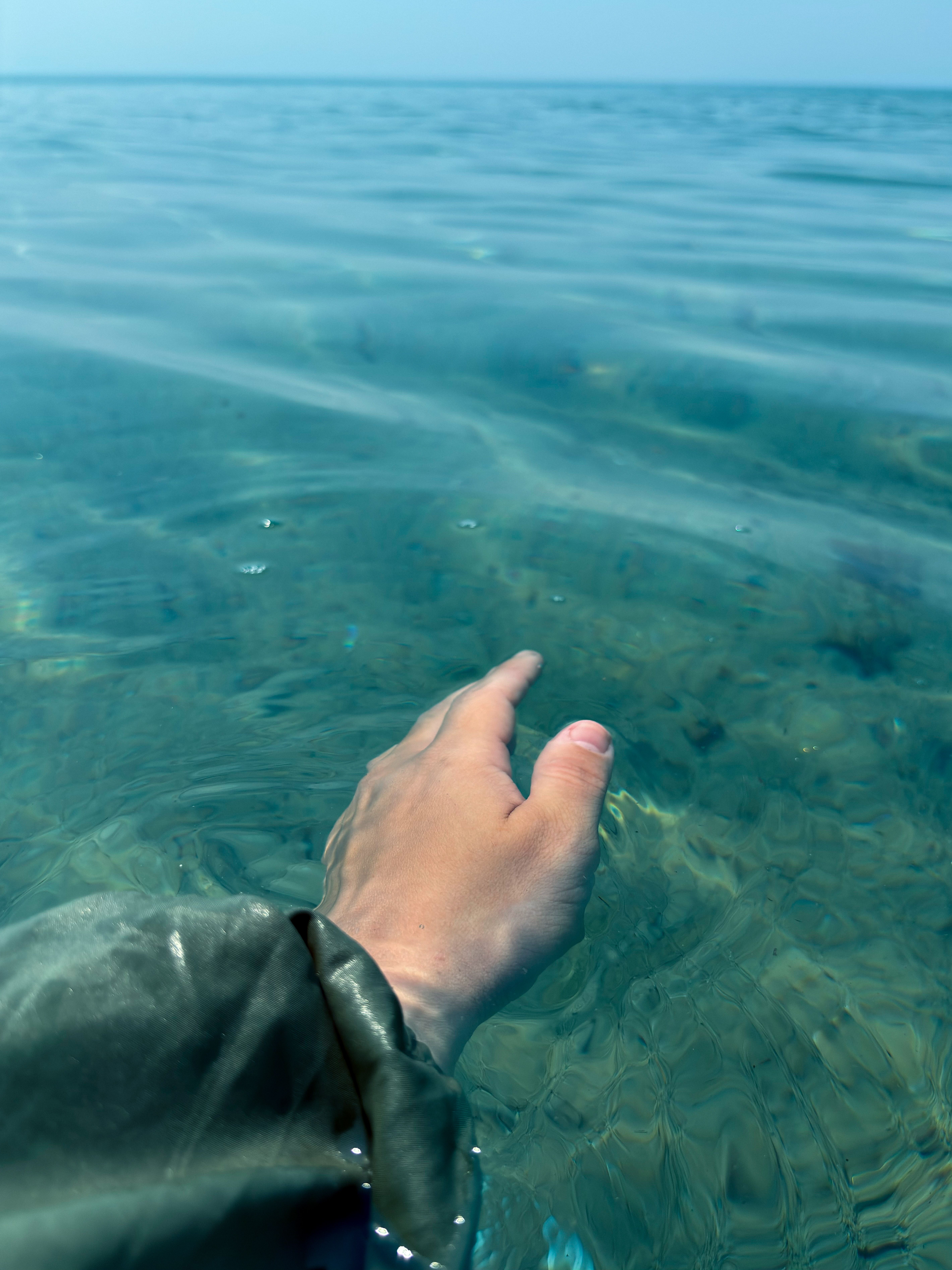 Hand Touching Clear Ocean Water Surface · Free Stock Photo