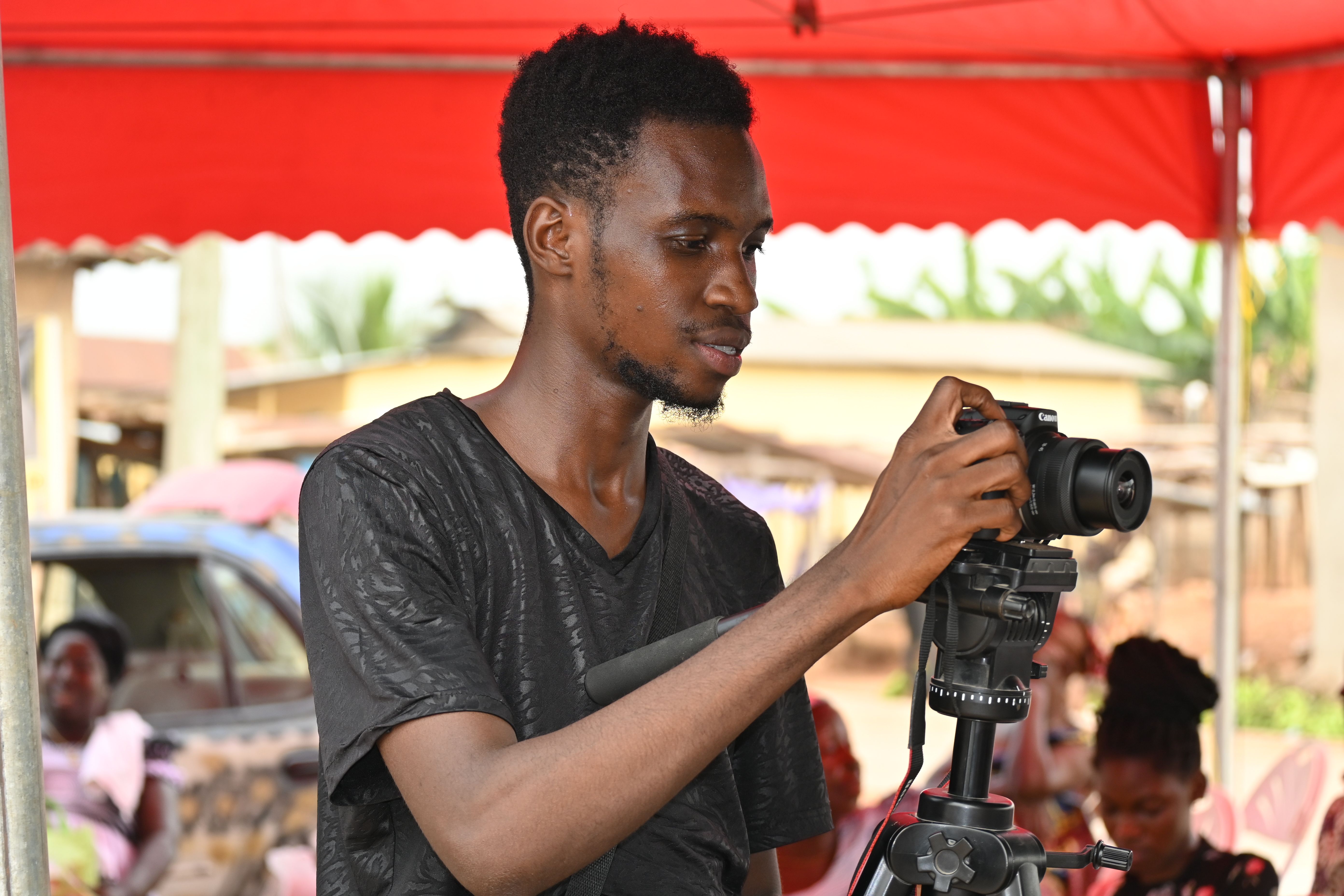 Young Photographer Adjusting Camera Setup Outdoors · Free Stock Photo