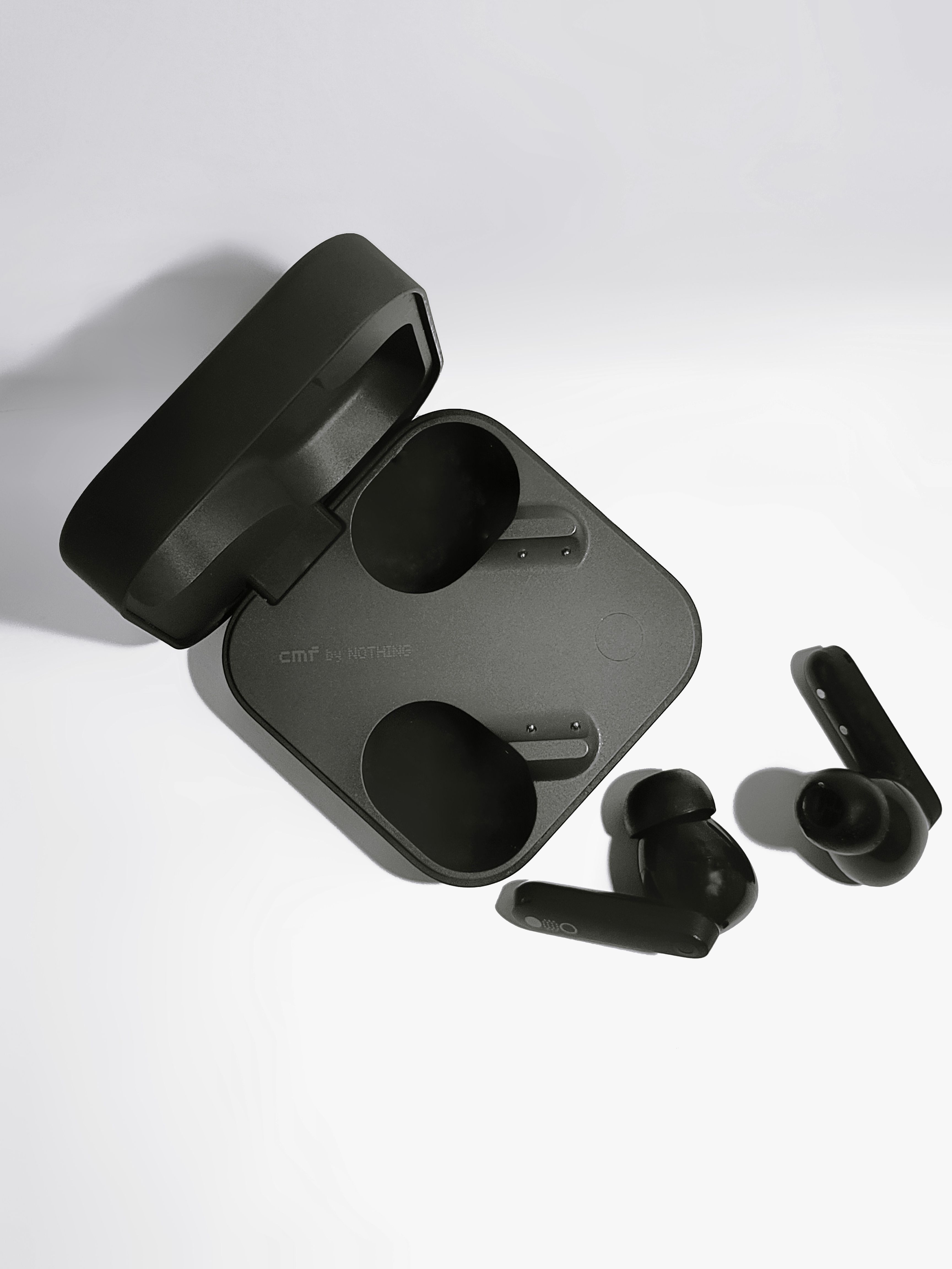 Minimalist Black Wireless Earbuds on White Background · Free Stock Photo