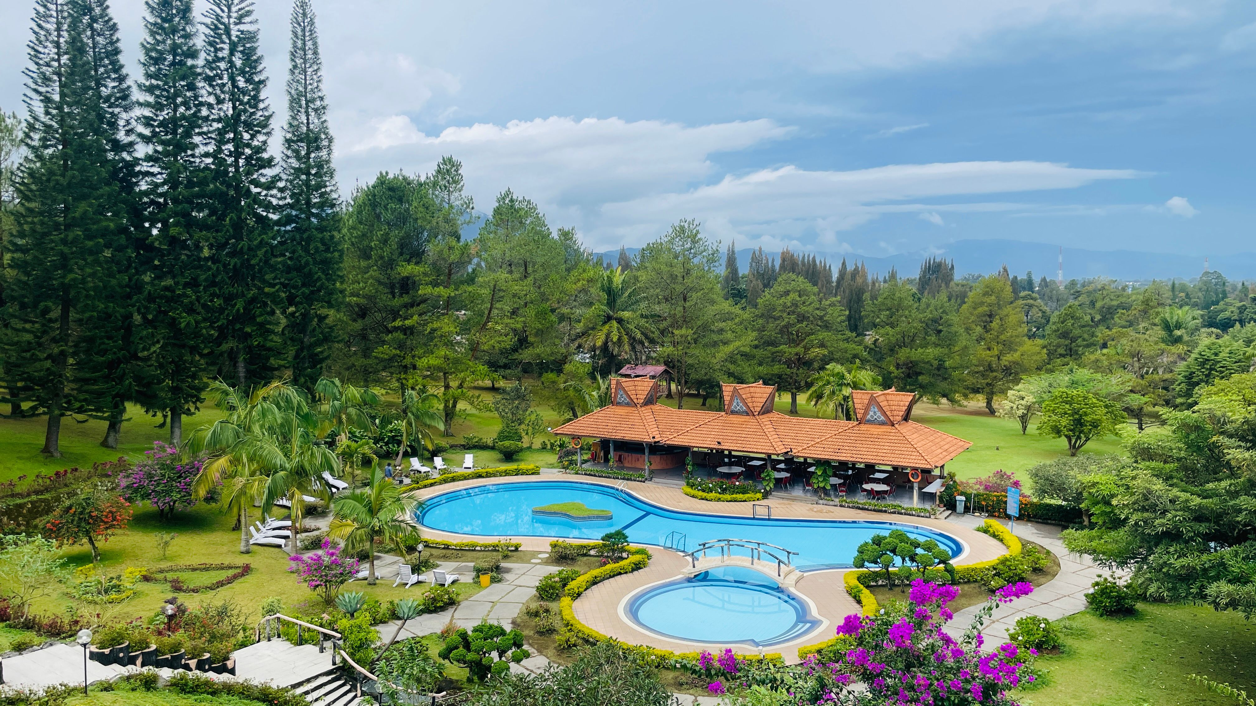 Serene Resort Landscape with Lush Gardens and Pool · Free Stock Photo