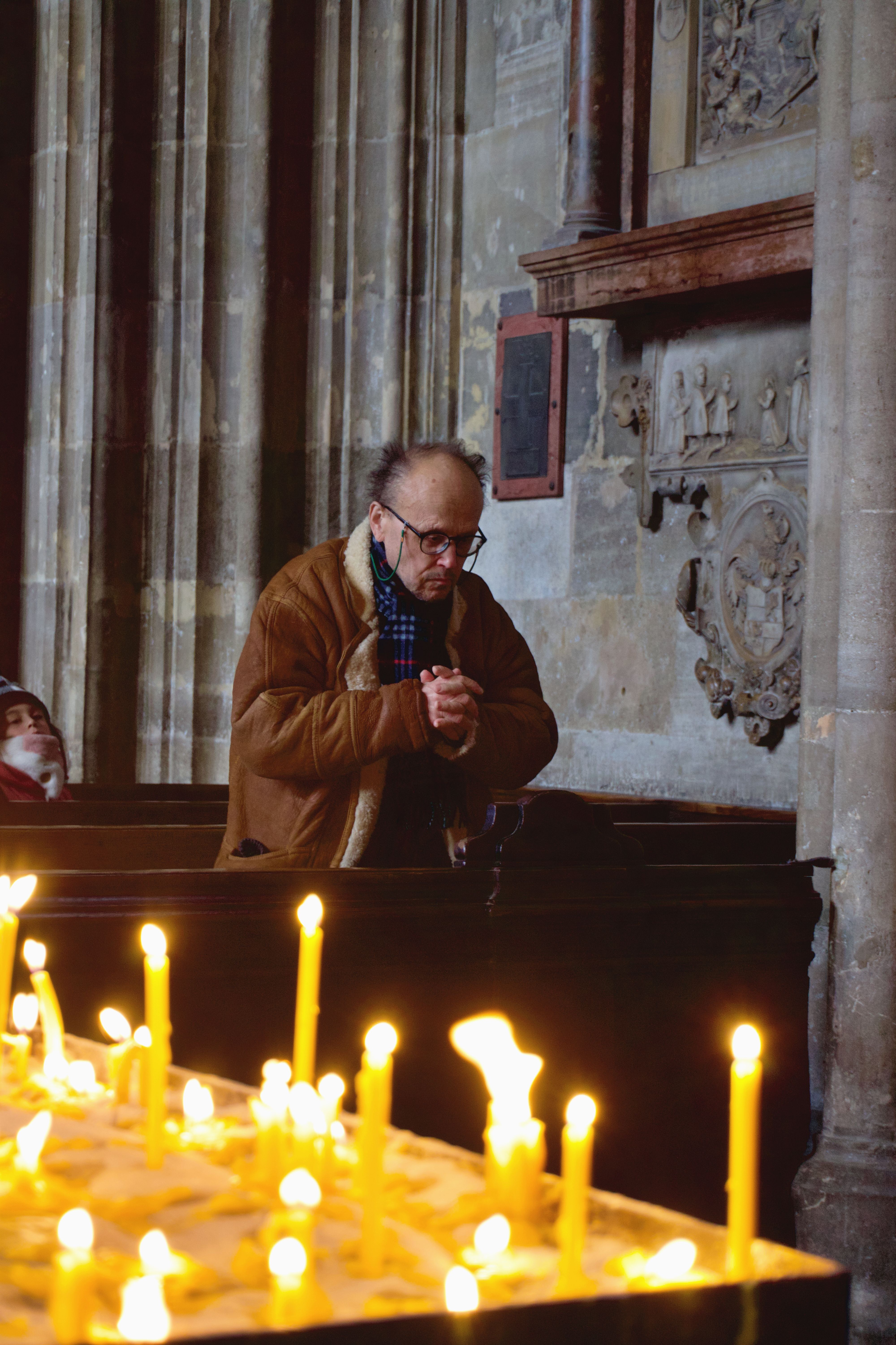 Elderly Man Praying in Historic Church Interior · Free Stock Photo