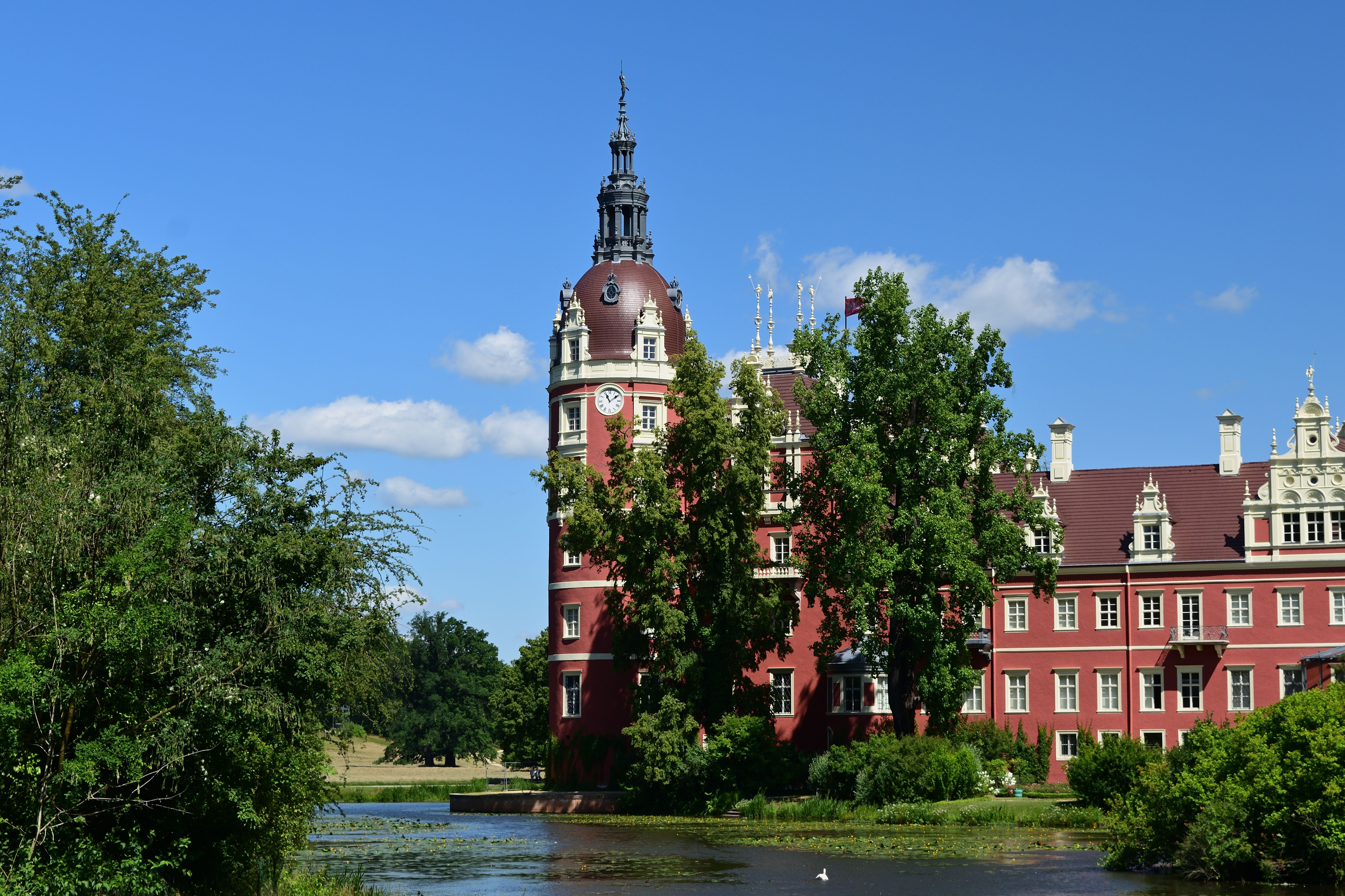 Majestic Red Castle Overlooking Tranquil Lake · Free Stock Photo