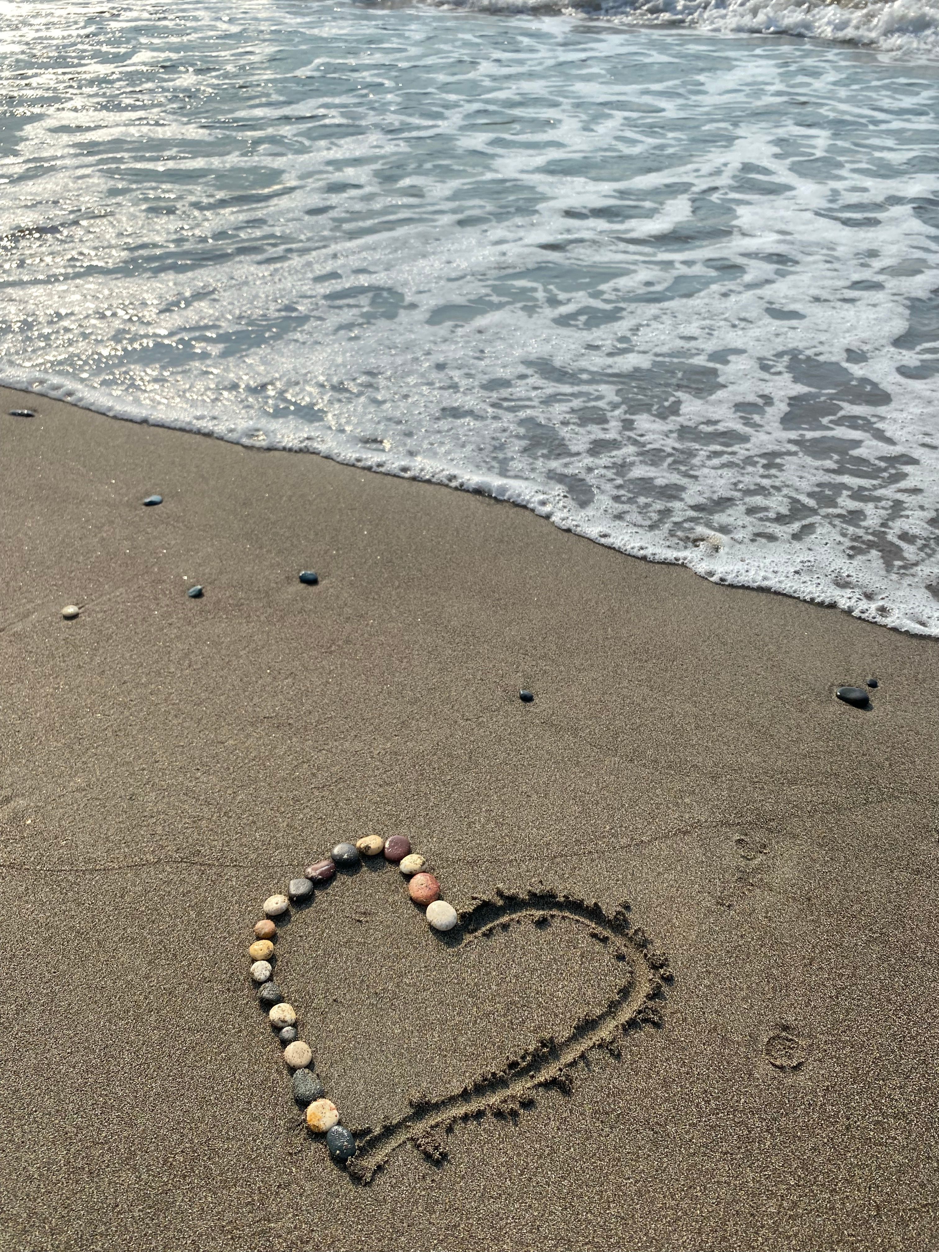 Heart-Shaped Pebble Art on a Sandy Beach · Free Stock Photo