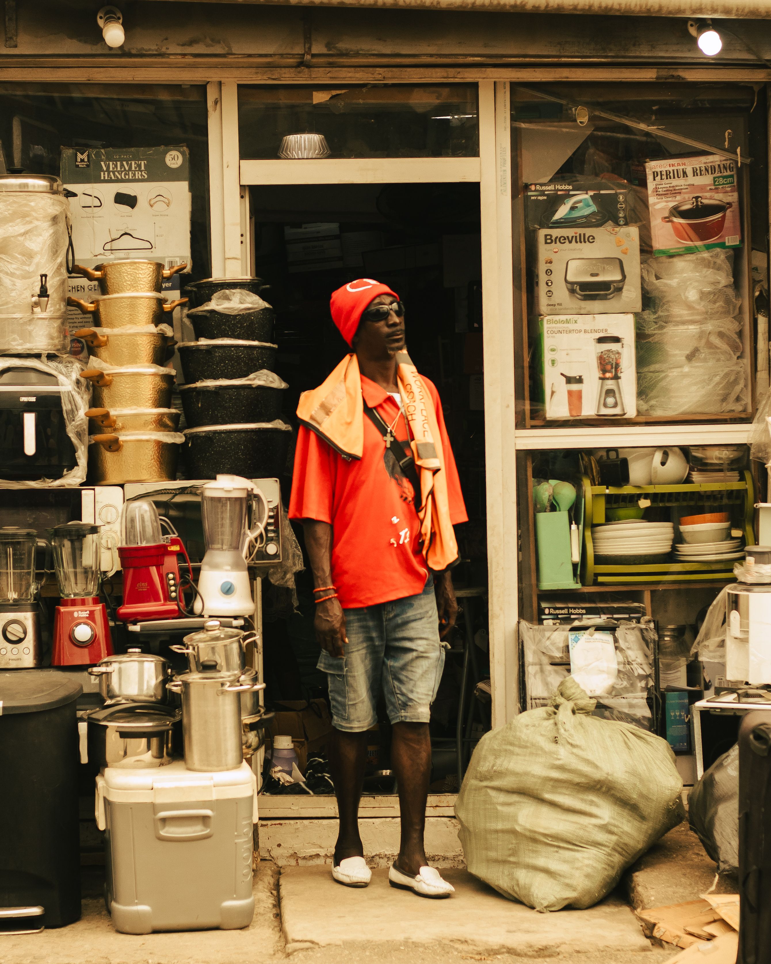 Man Standing at a Market Stall with Appliances · Free Stock Photo