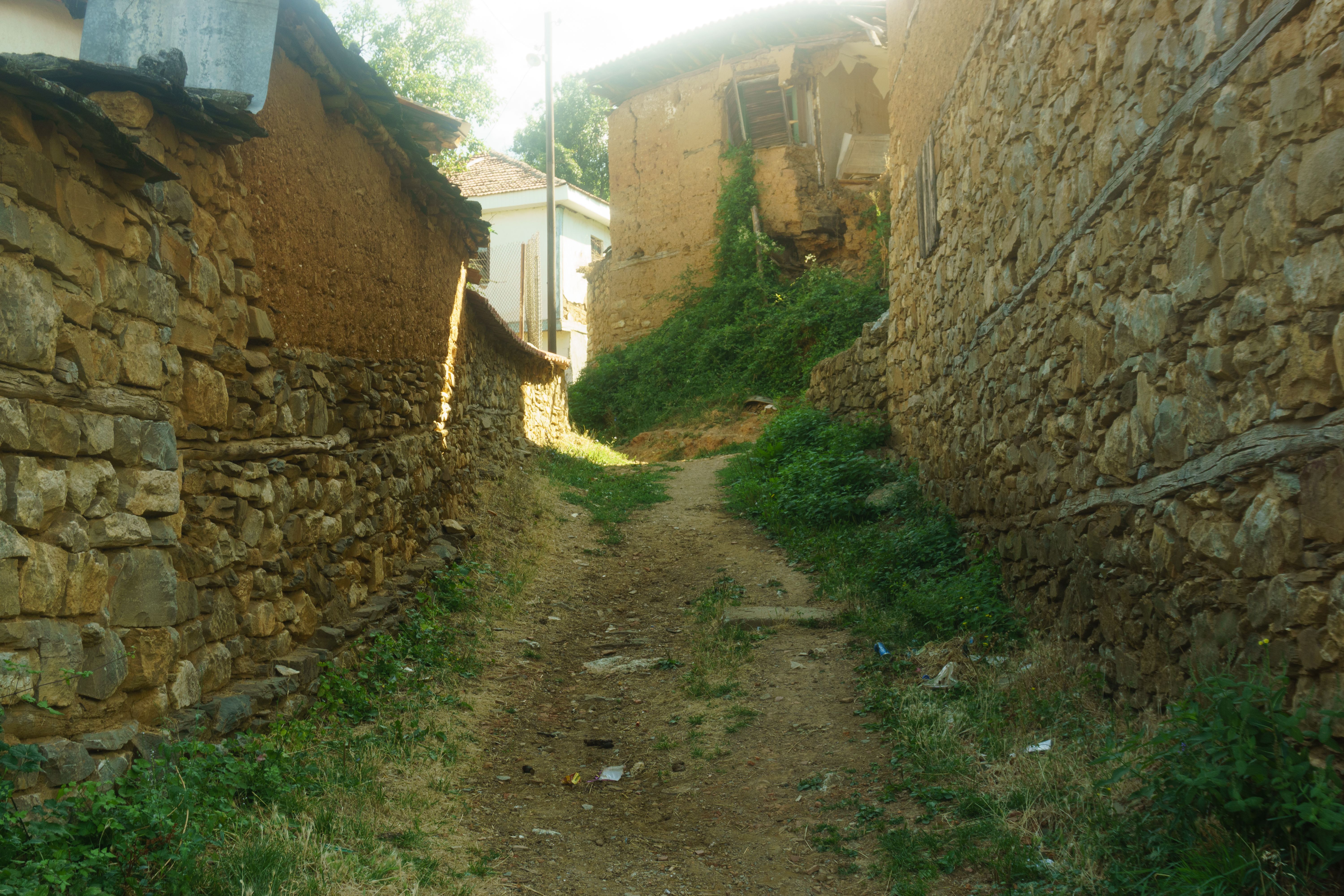 Charming Rural Village Pathway with Old Stone Walls · Free Stock Photo