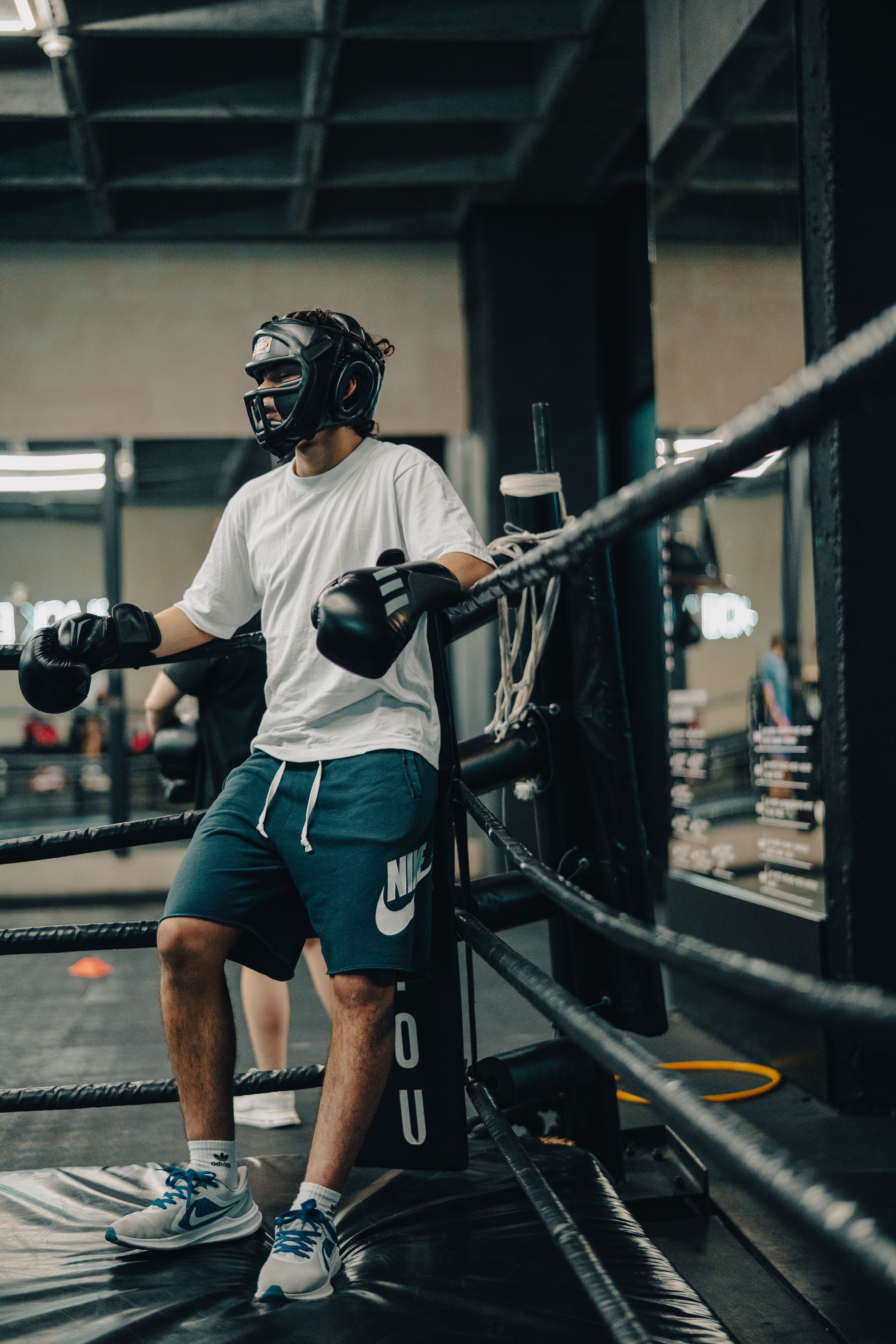 Boxer Resting in Gym Ring with Gloves and Helmet · Free Stock Photo