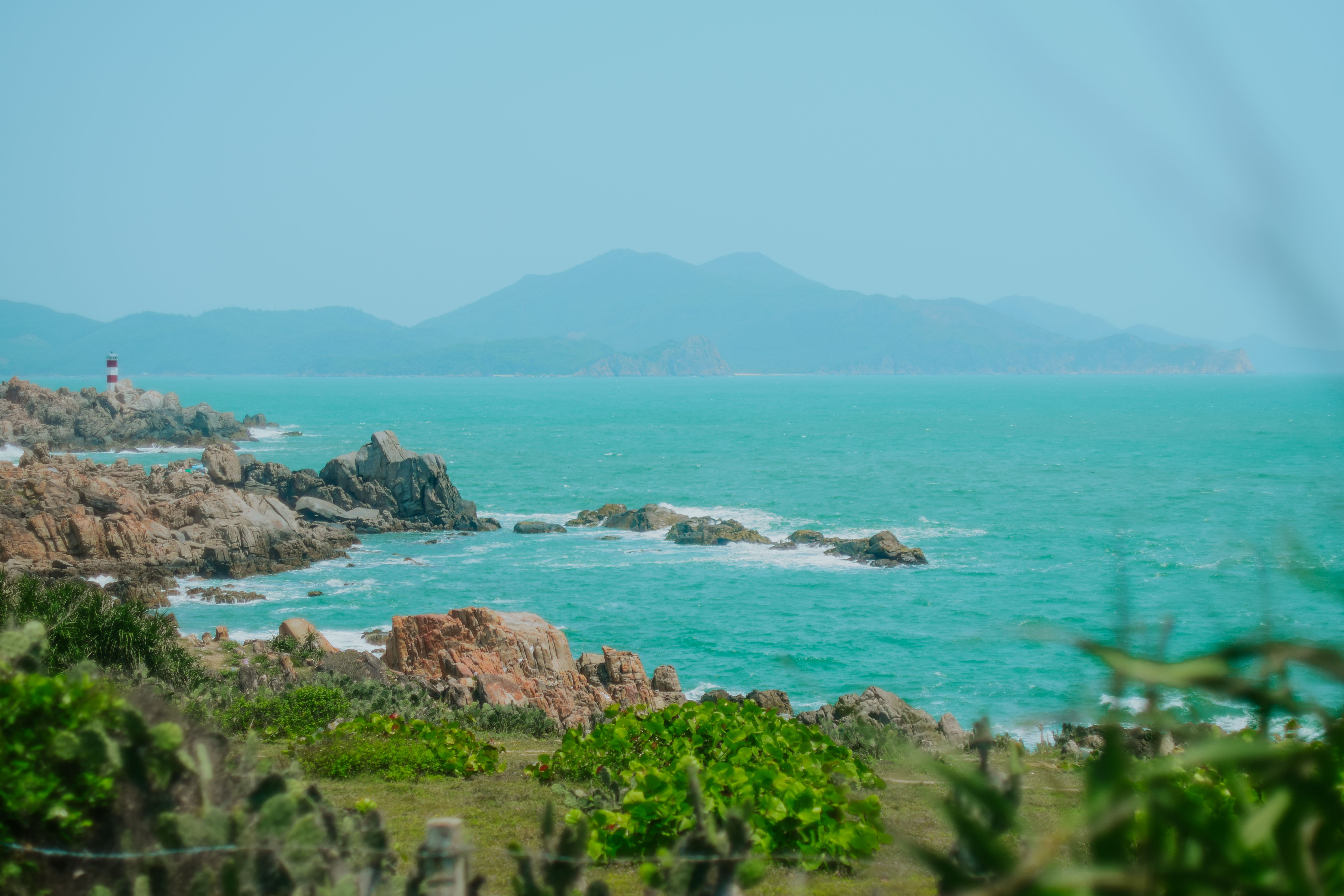 Scenic Coastal View with Rocky Shoreline and Lighthouse · Free Stock Photo