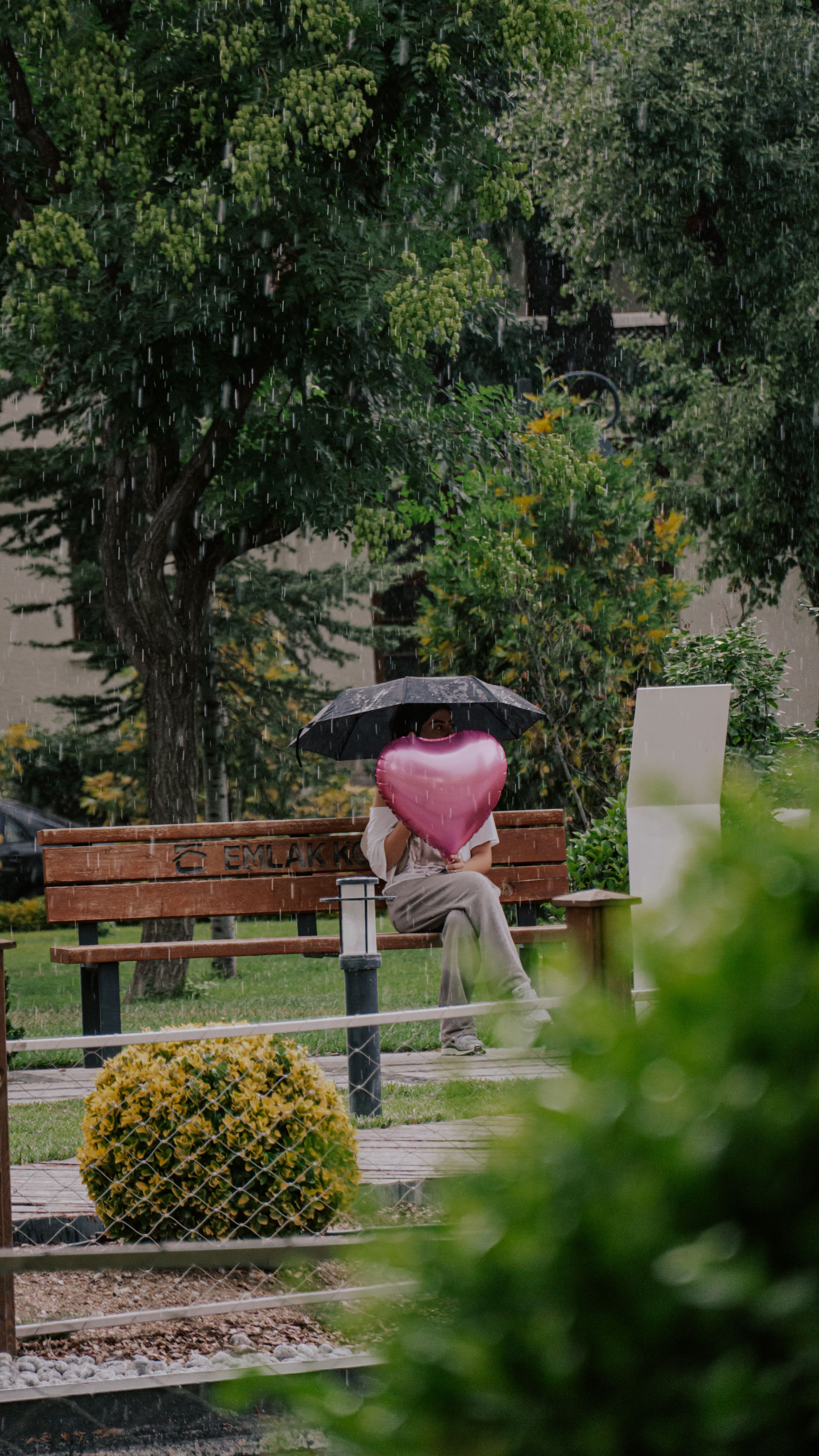 Person on Park Bench with Heart Balloon in Rain · Free Stock Photo