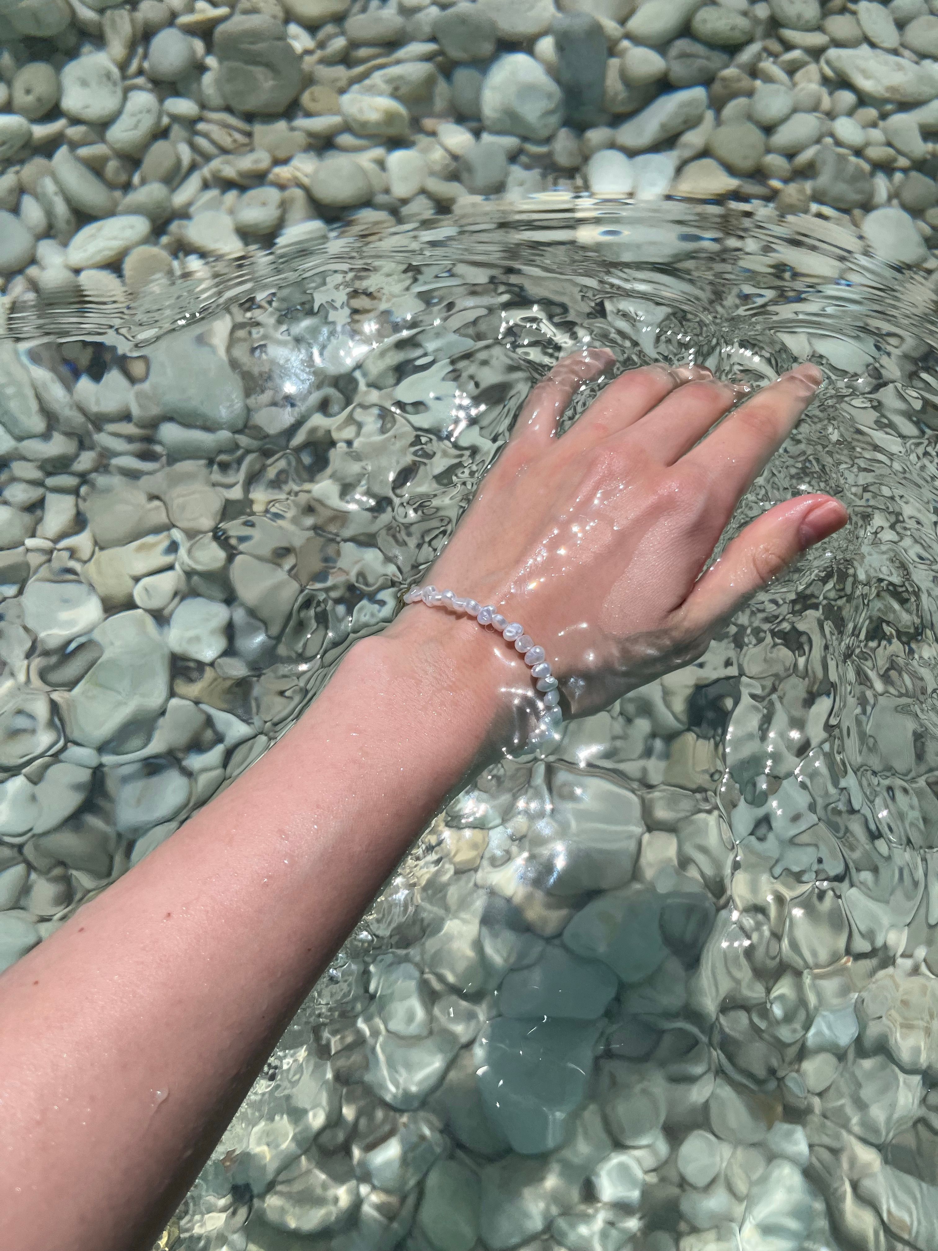 Hand with Bracelet in Clear Pebble Sea Water · Free Stock Photo