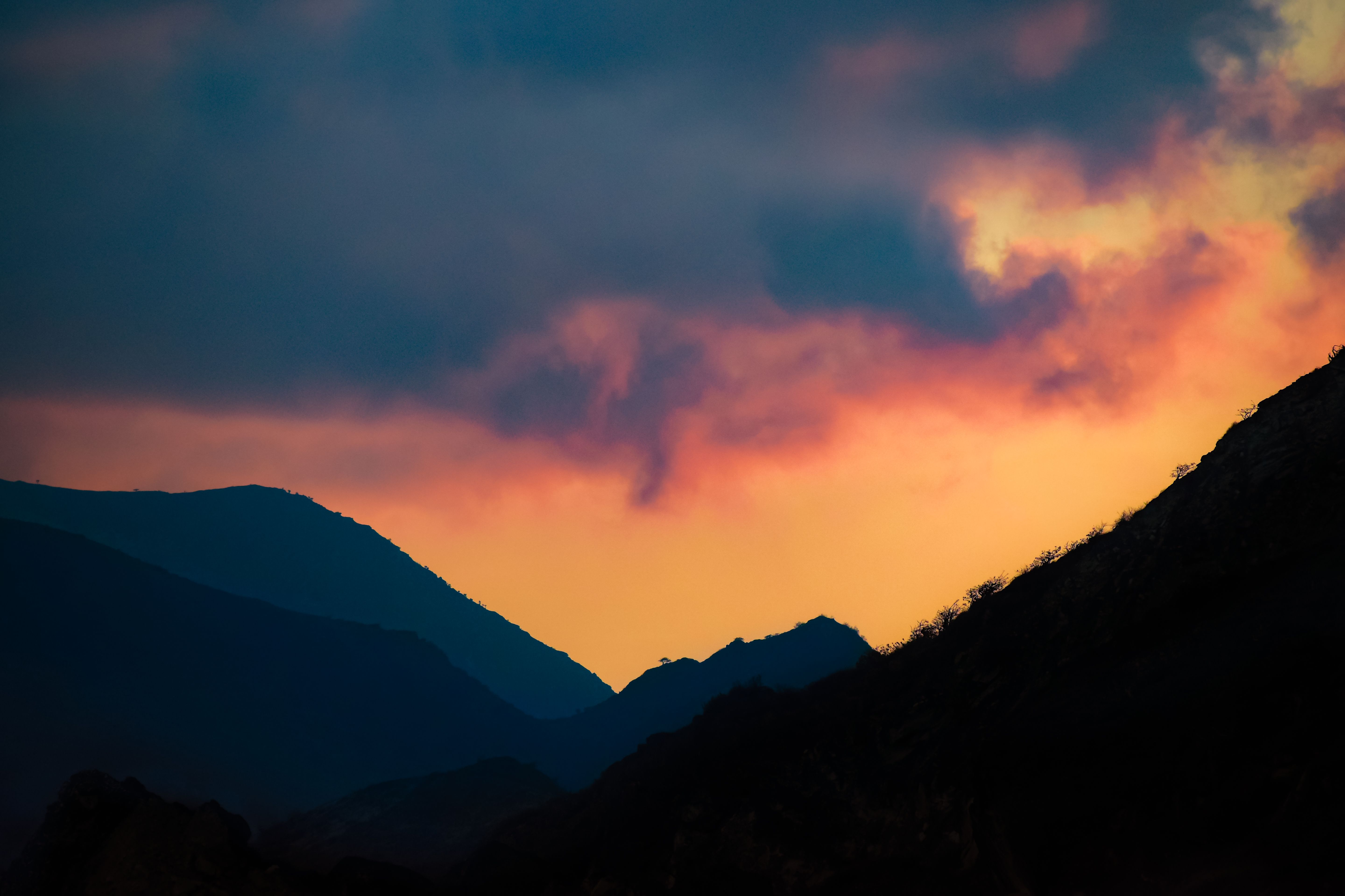 Dramatic Sunset Over Mountain Silhouettes · Free Stock Photo