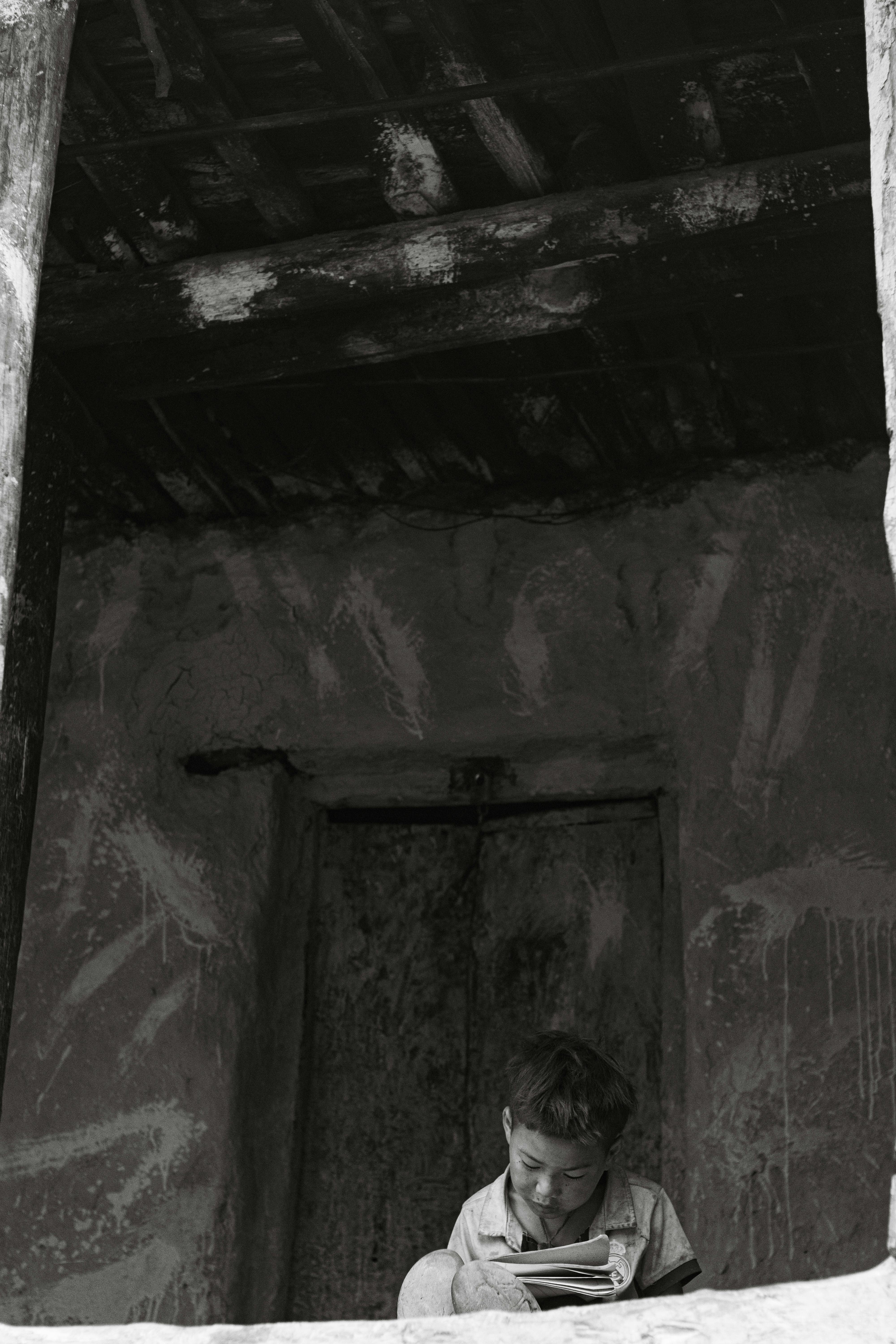 Reflective Child Reading in Rustic Setting · Free Stock Photo