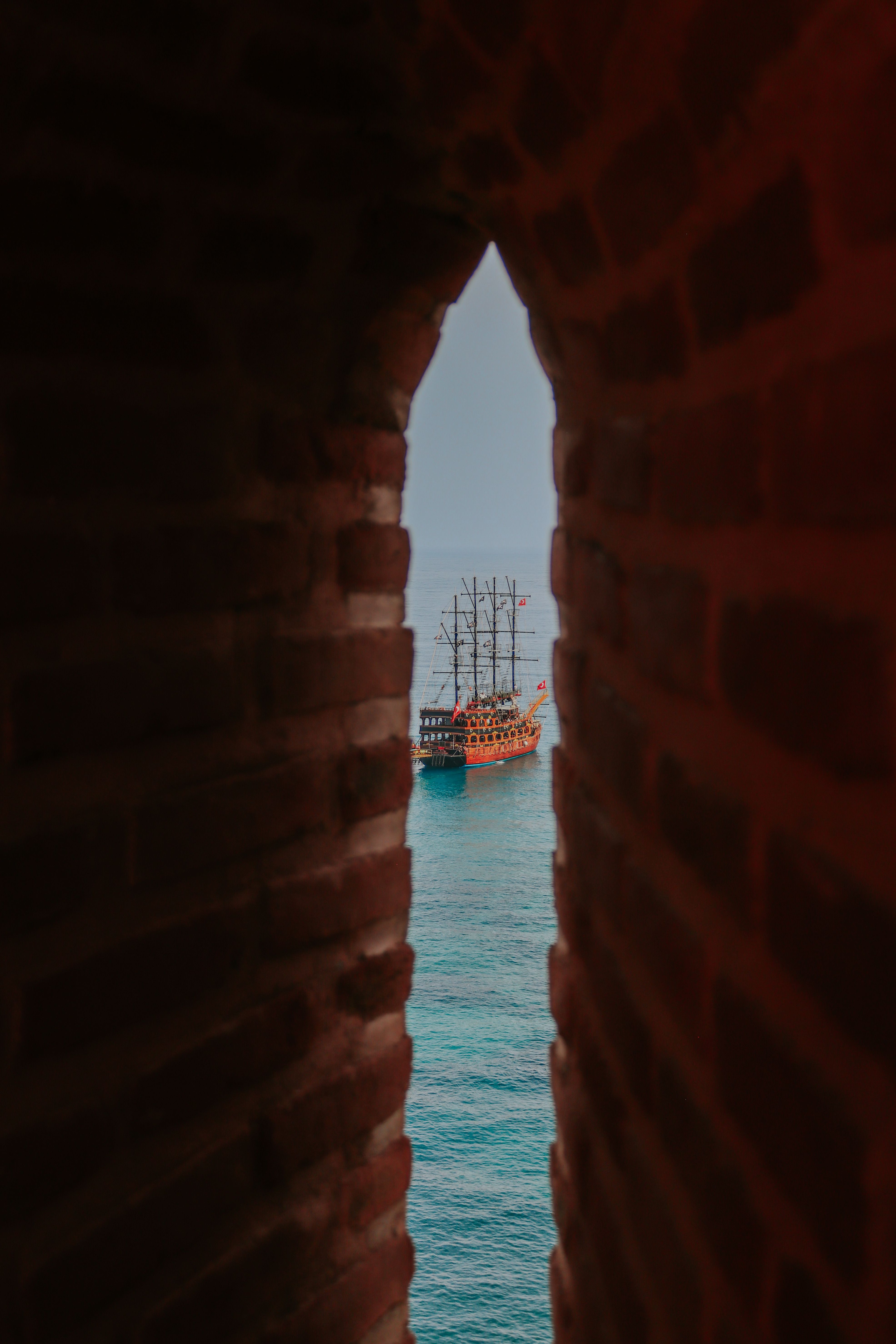 Scenic View of Pirate Ship Through Stone Archway · Free Stock Photo