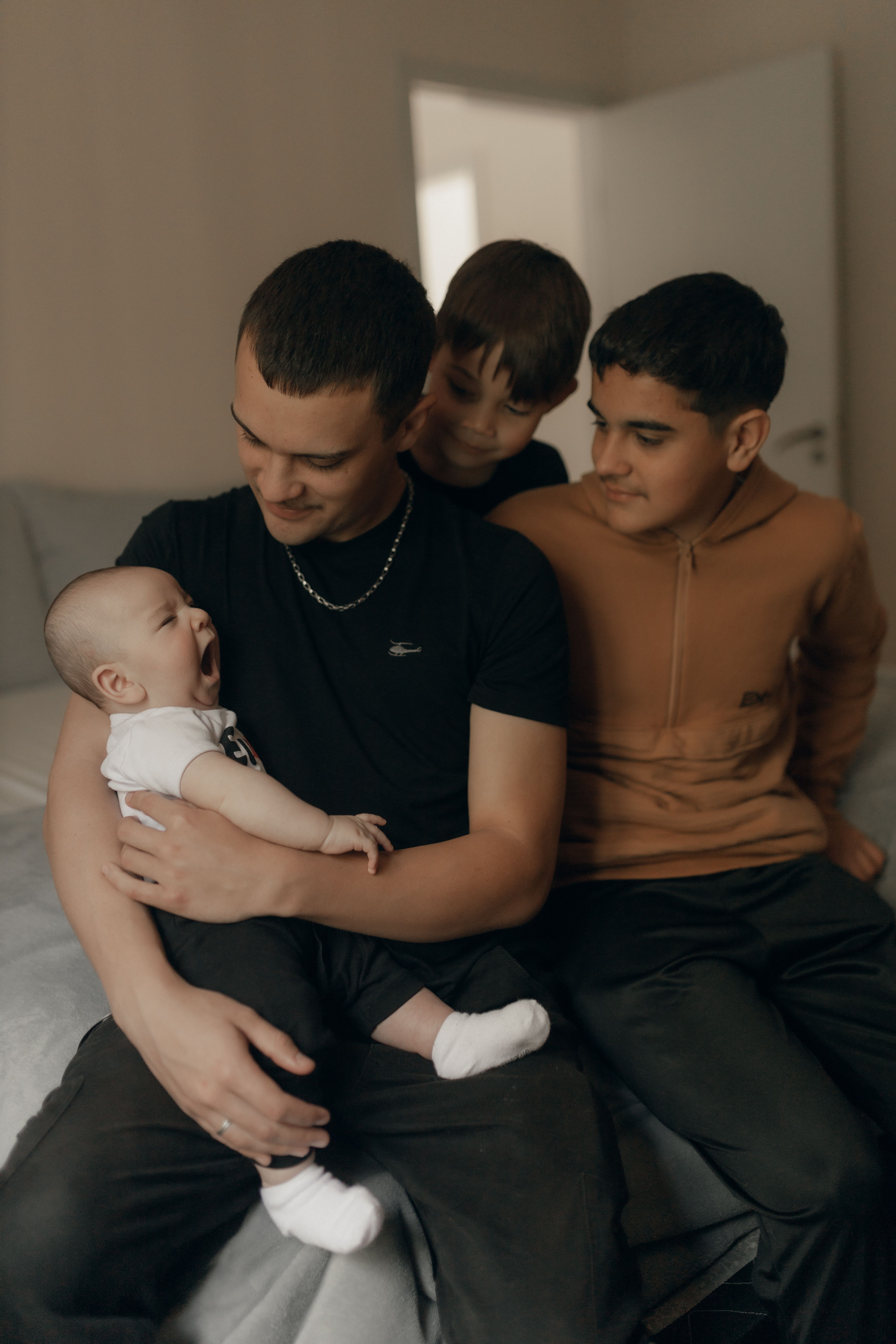 Family Bonding Moment with Brothers and Baby · Free Stock Photo