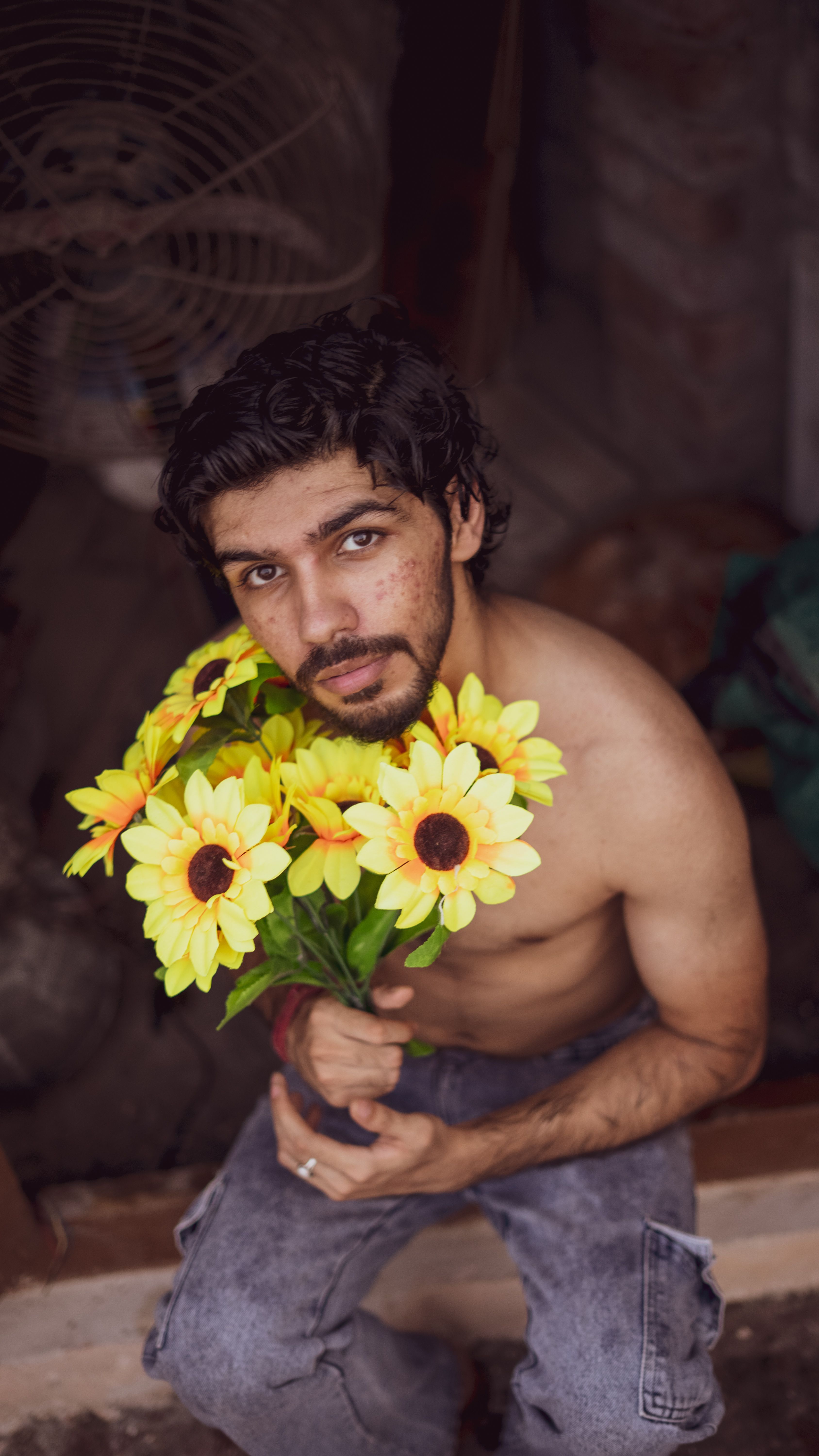 Young Man Holding Bright Sunflowers Indoors · Free Stock Photo