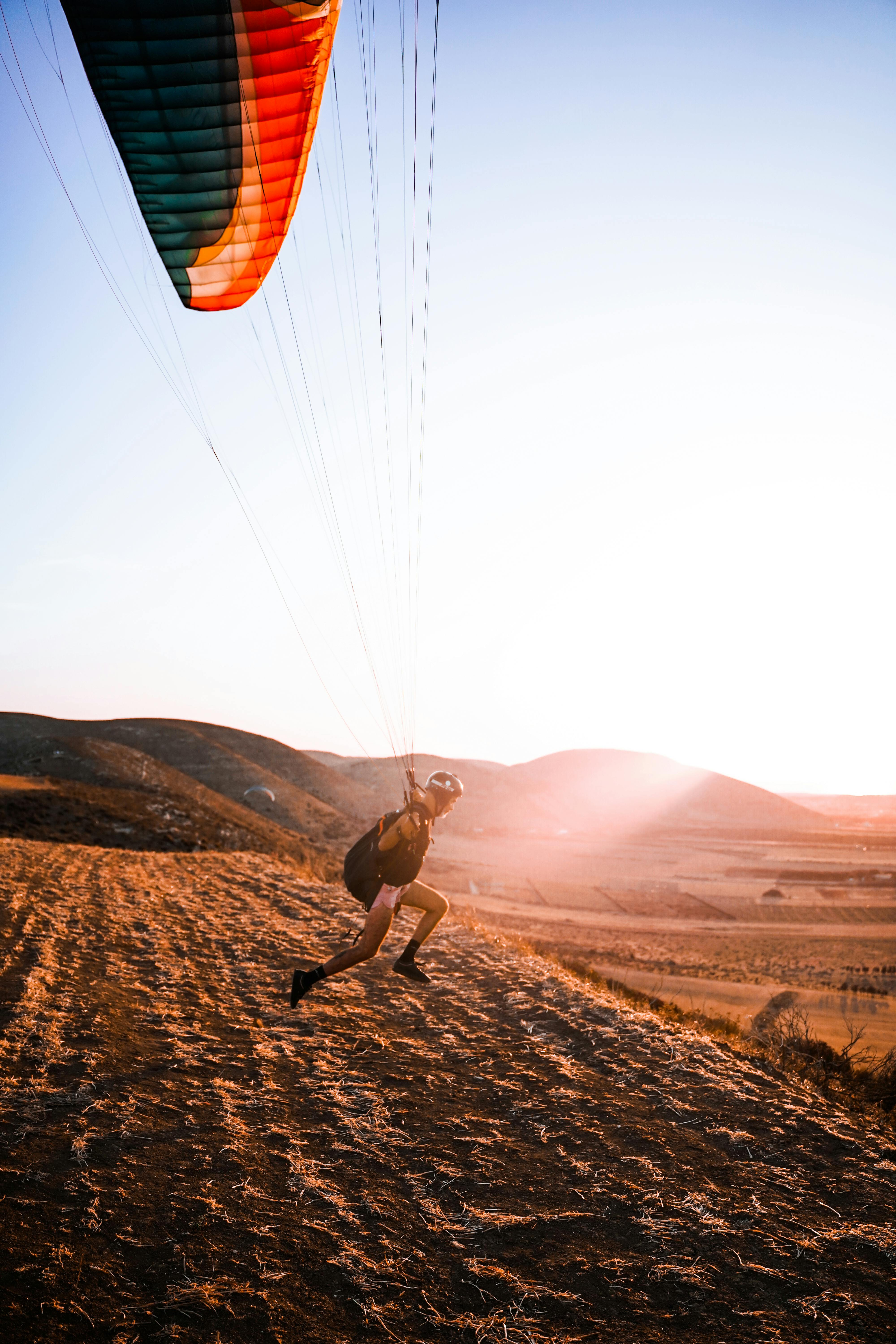 A Person with a Paraglider Landing on the Field · Free Stock Photo
