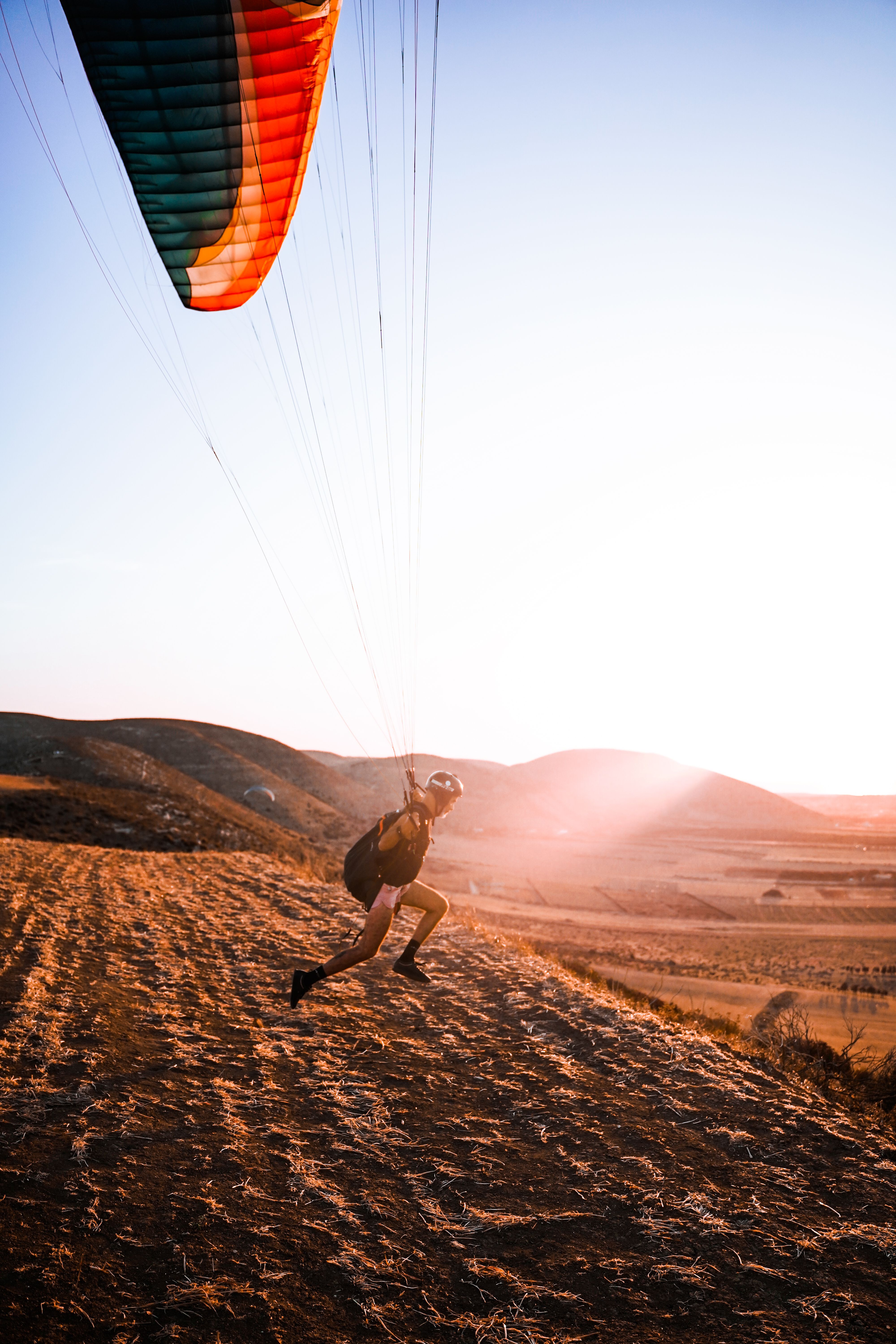 Paraglider Taking Off at Sunset in Hilly Landscape · Free Stock Photo