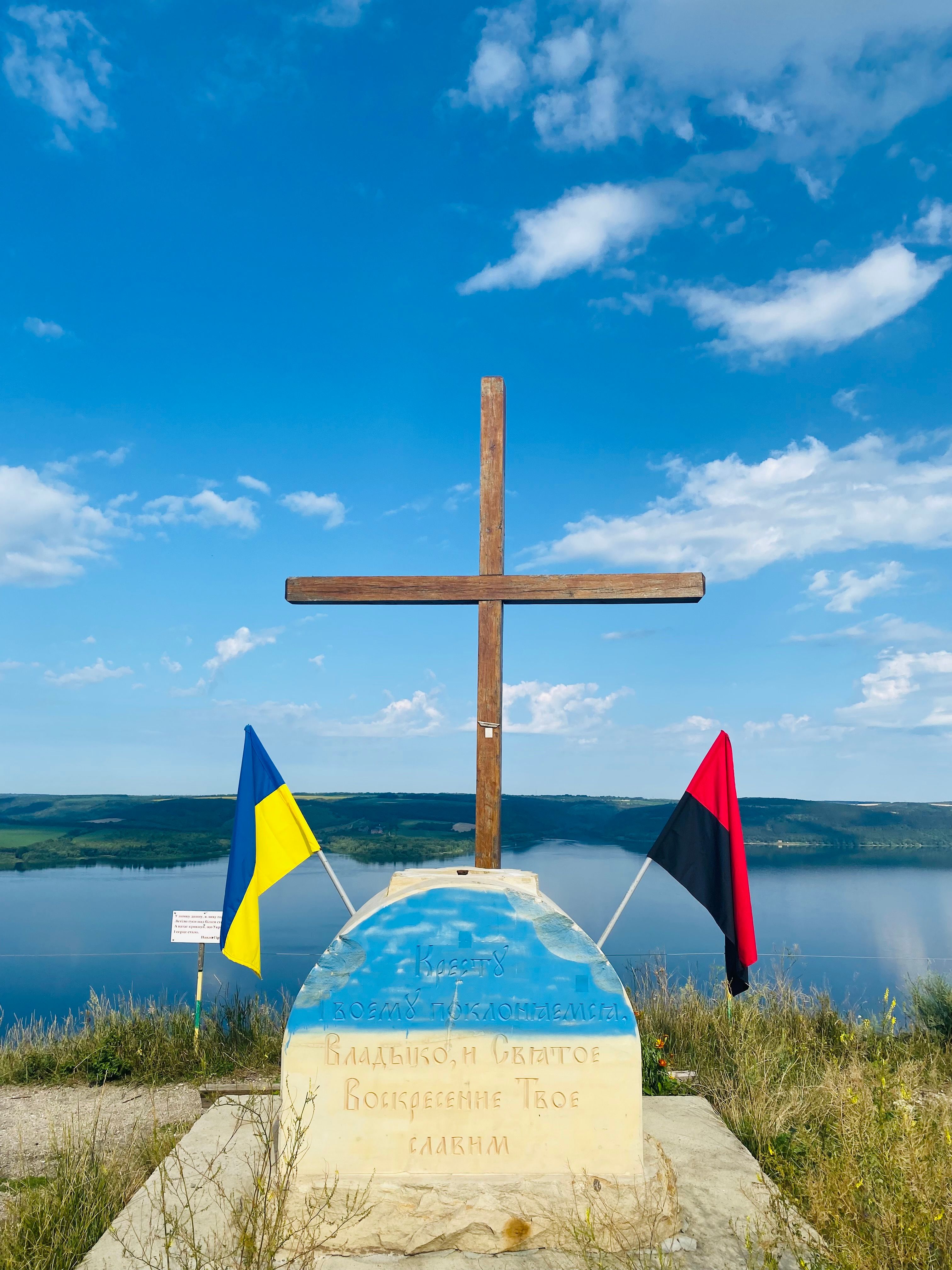Cross Monument with Flags Overlooking River Landscape · Free Stock Photo