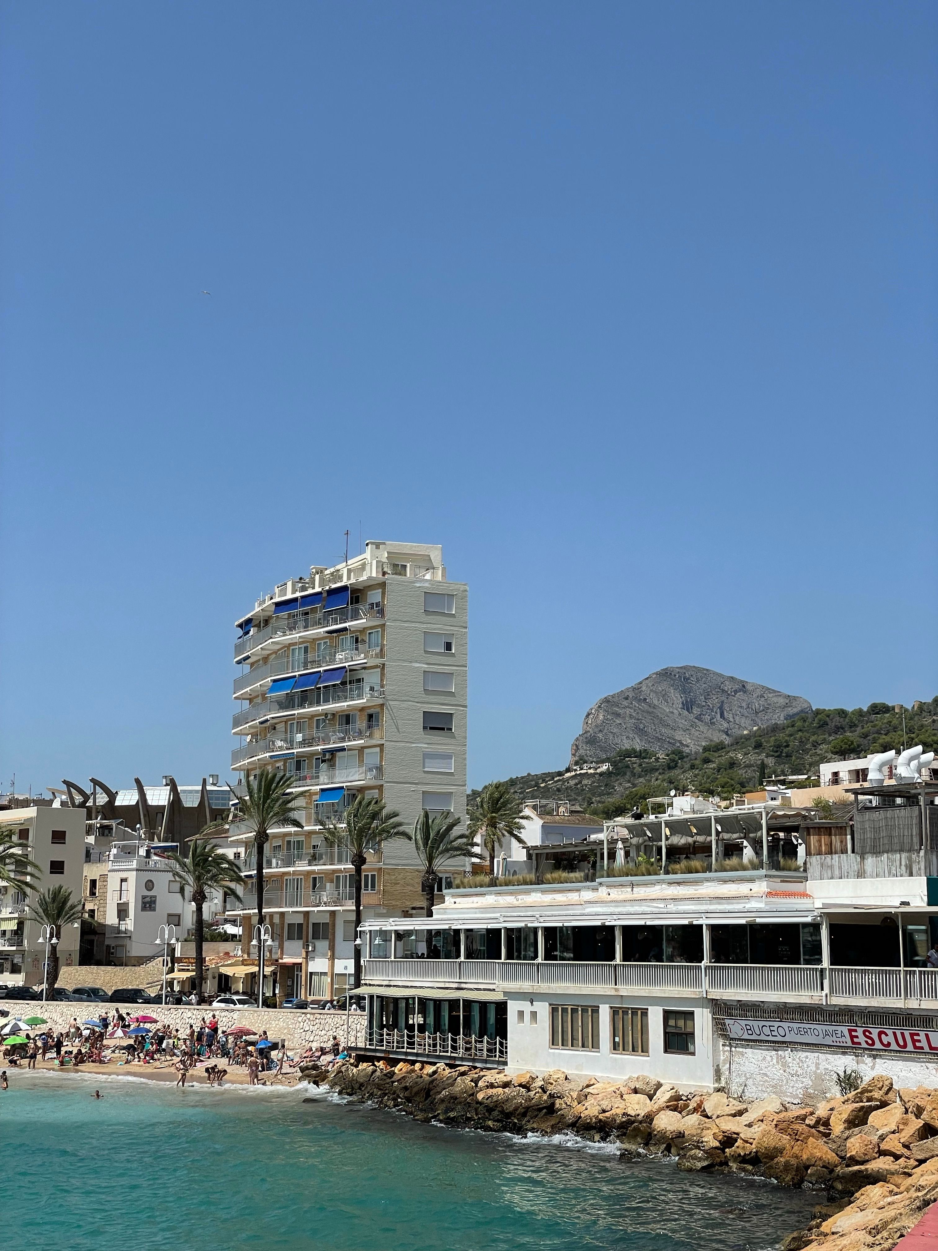 Coastal View of Beachfront Buildings and Mountain · Free Stock Photo