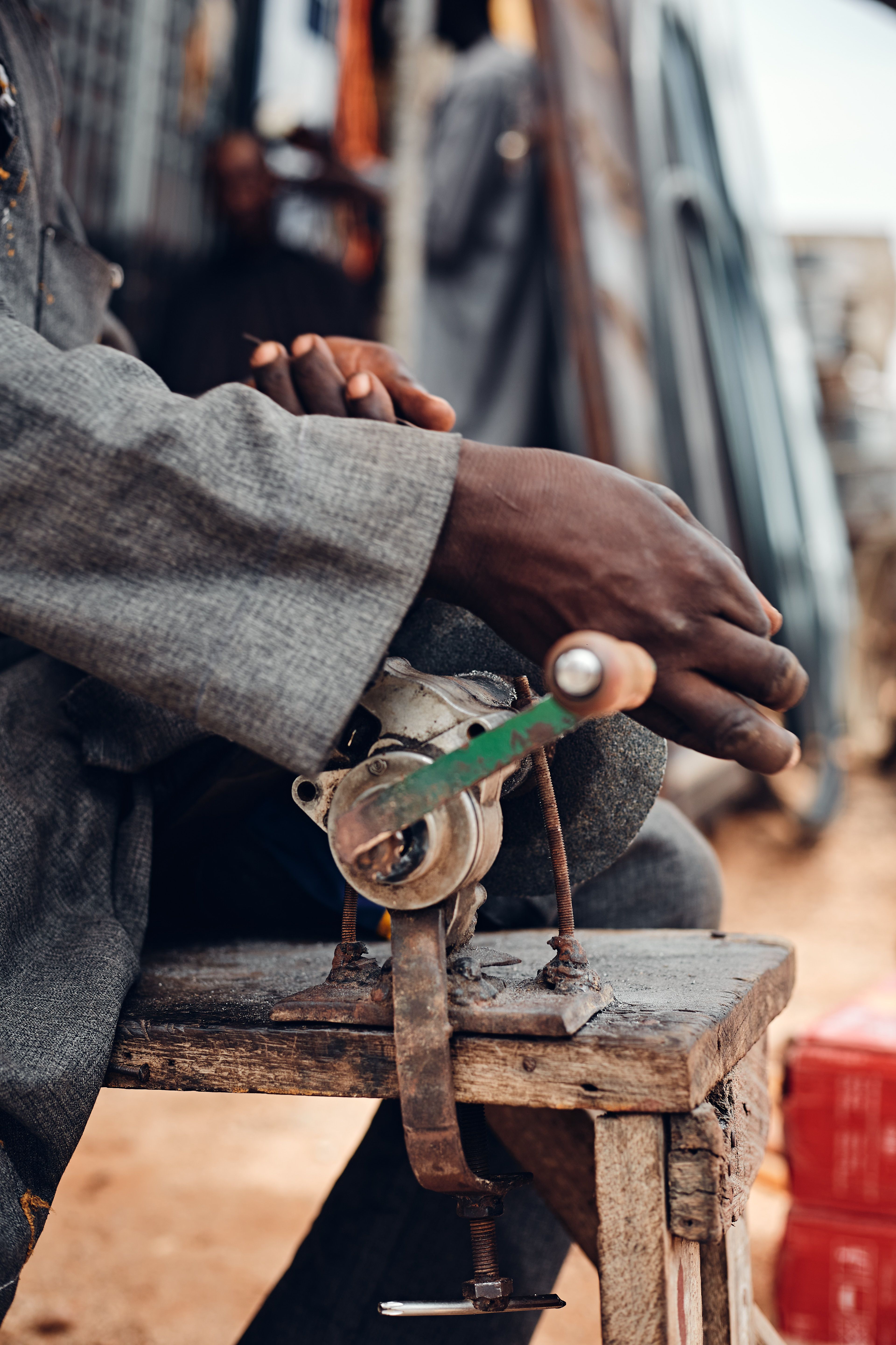 Close-up of Hands Operating a Traditional Grinding Tool · Free Stock Photo